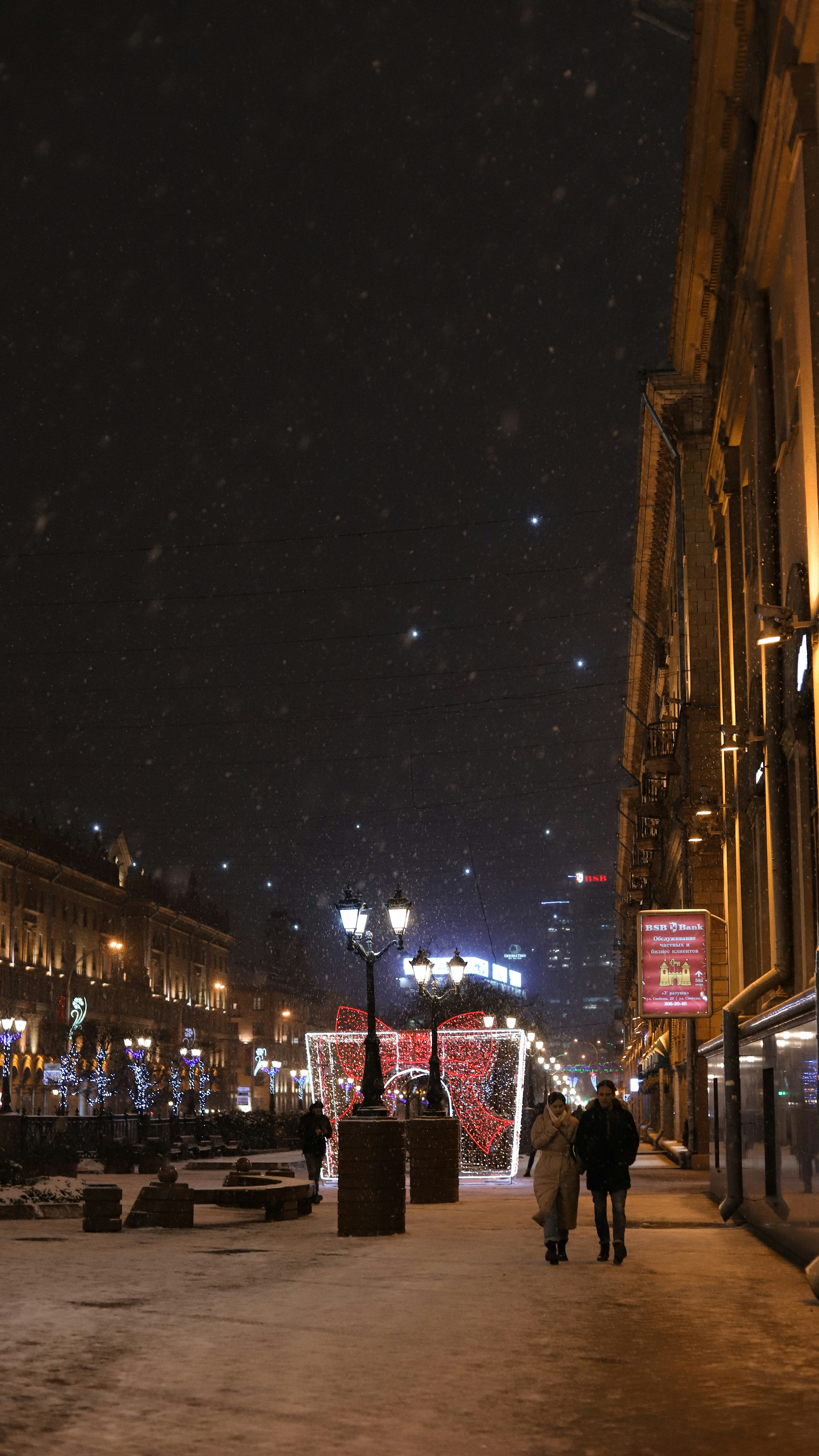 Heartlit Archways at Night: Snowy Street Walk Beneath Warm Streetlamps