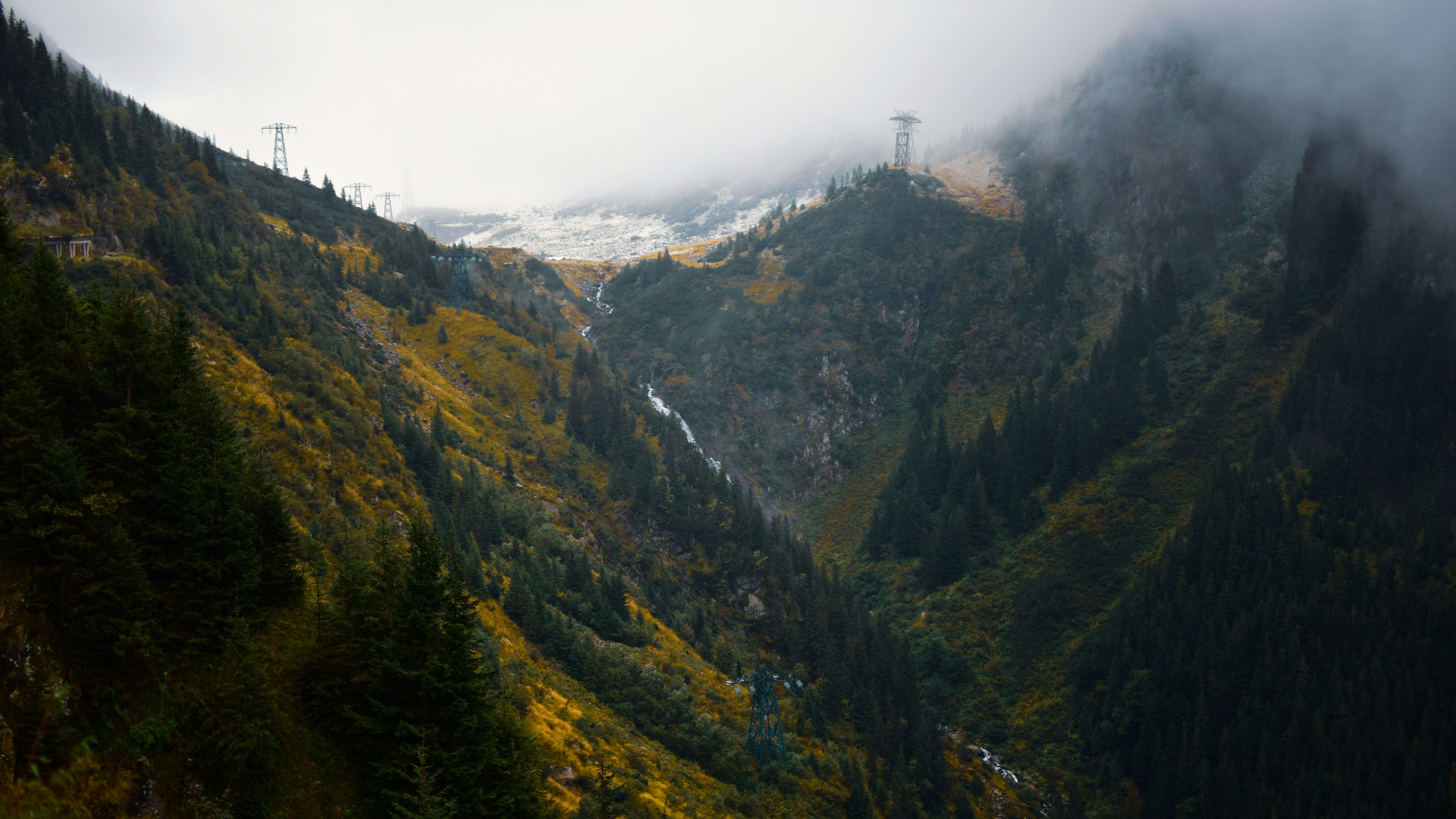 Ember Valleys and a Snow Crest: A Misty Alpine Gorge