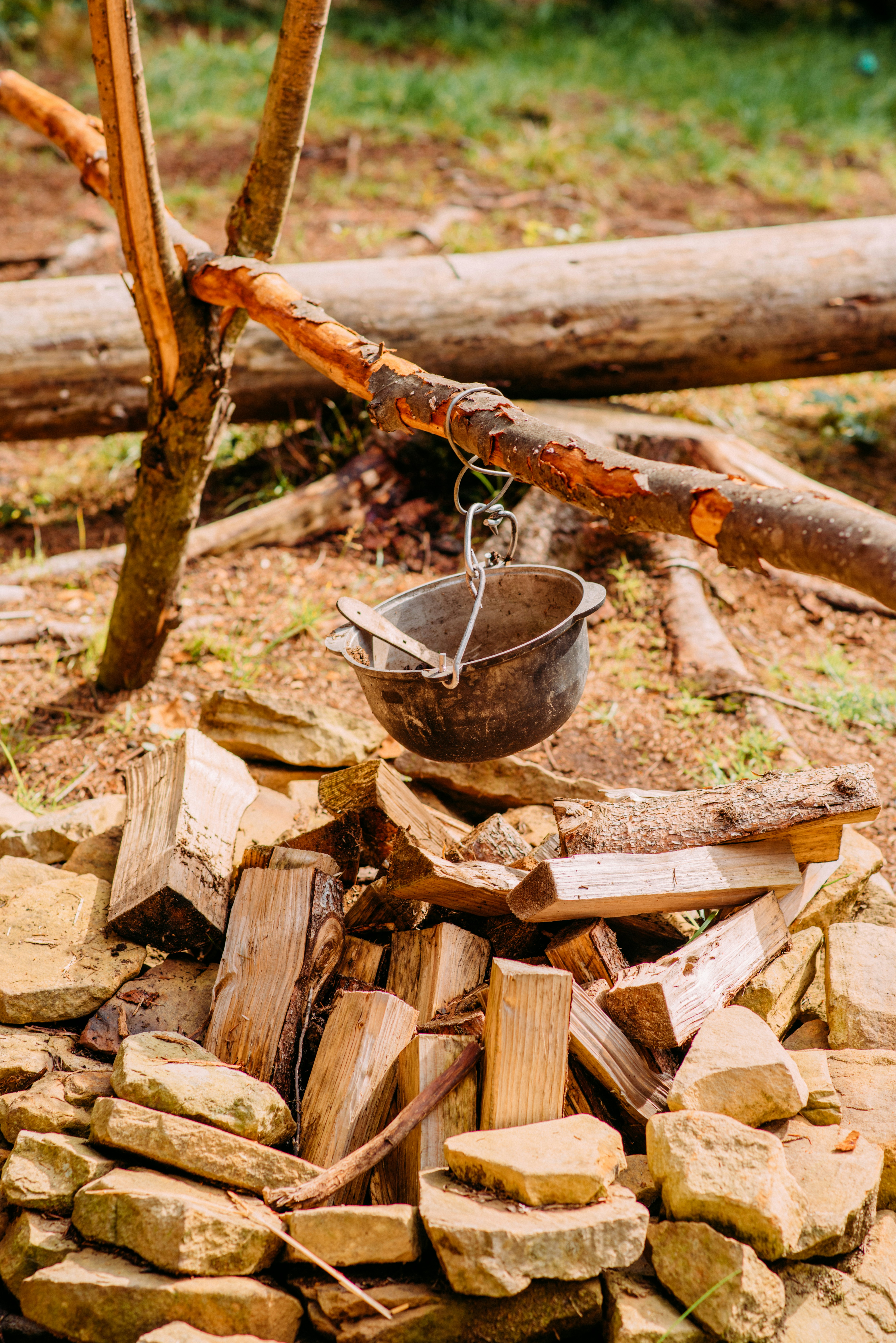 Suspend the Fire: A Cast Iron Pot Hangs Over Charred Wood