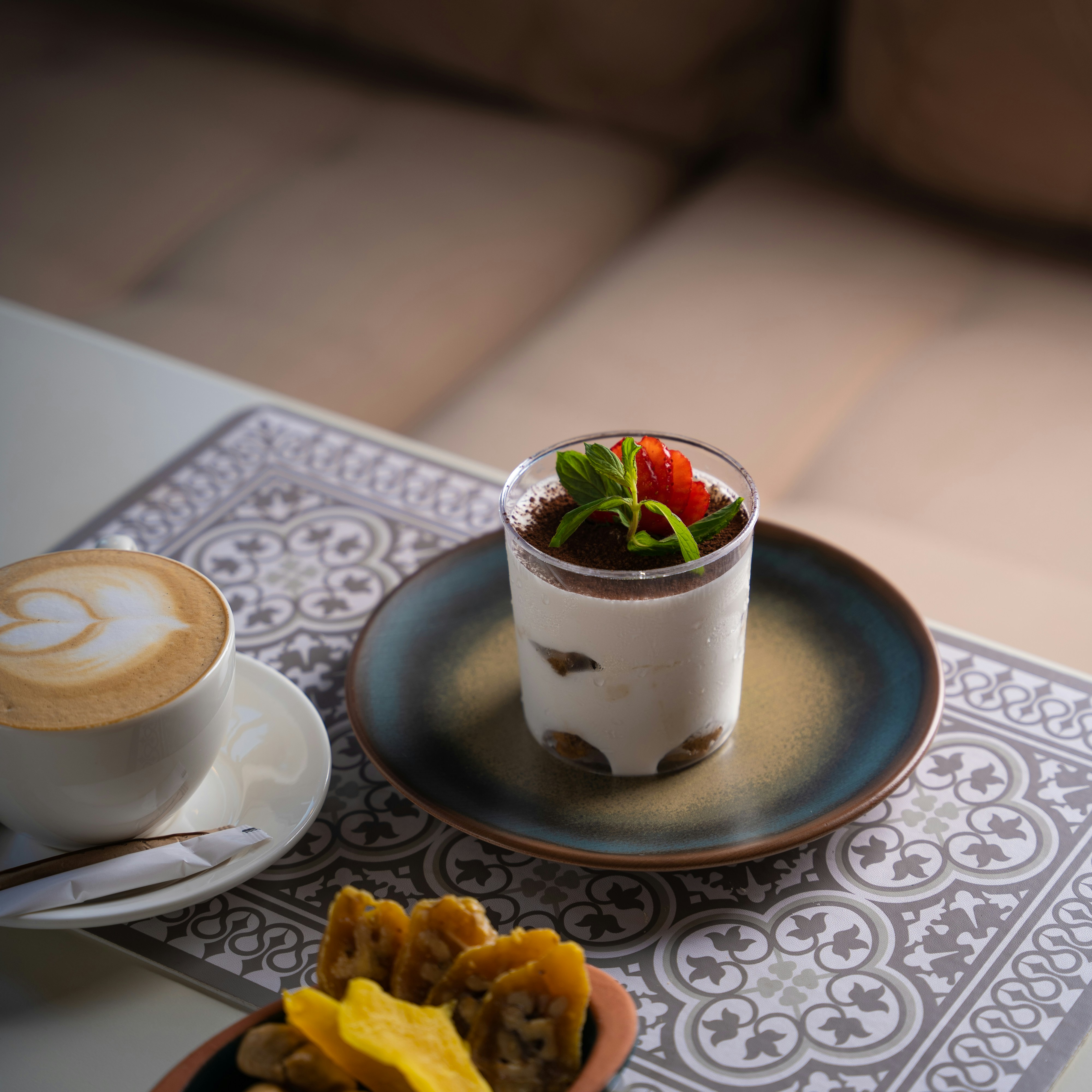 Dessert in Focus: A Tinted Glass Dream beside a Foamy Cappuccino