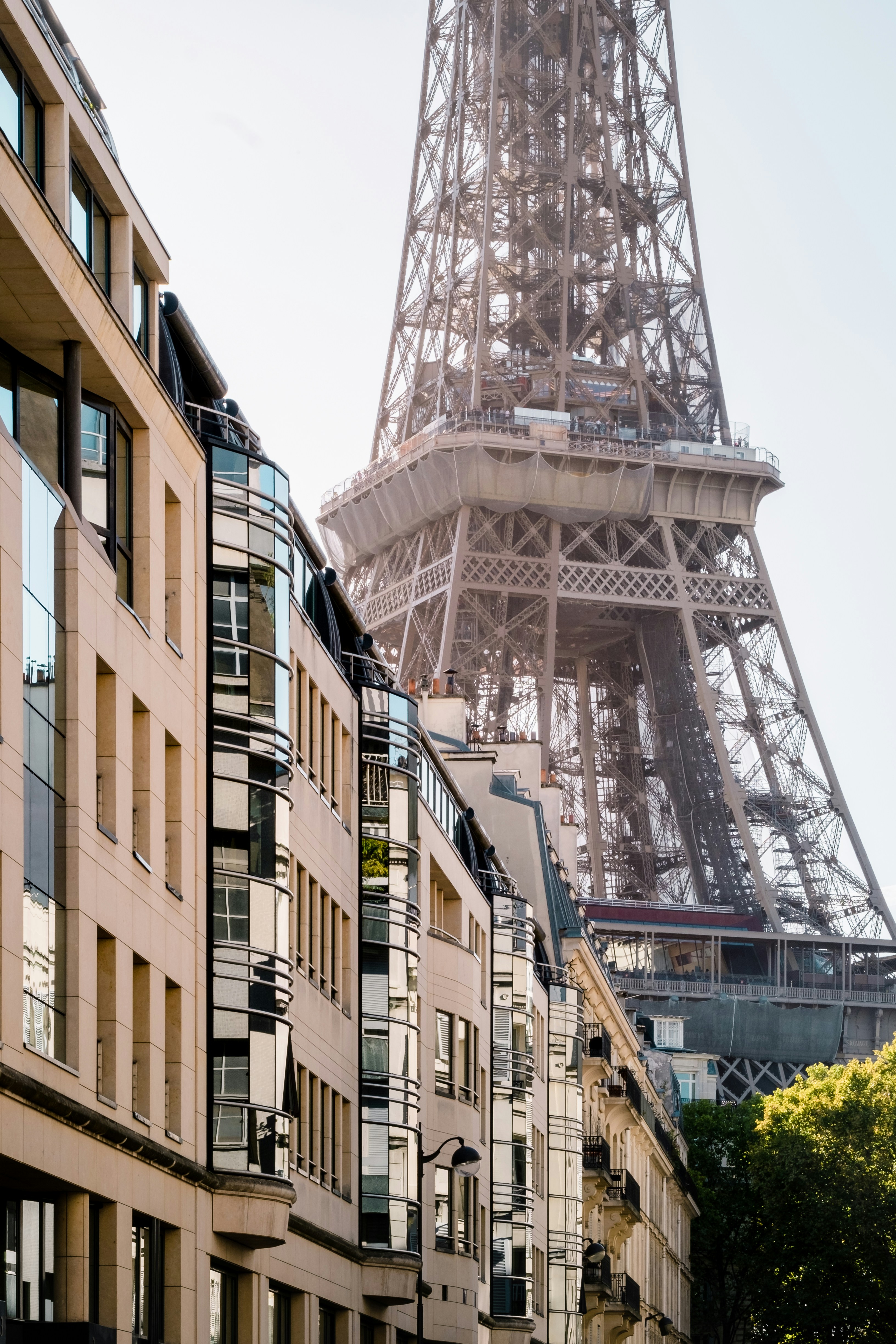 Iron Lattice Over a City Street: Eiffel Tower Framed by Modern Façades