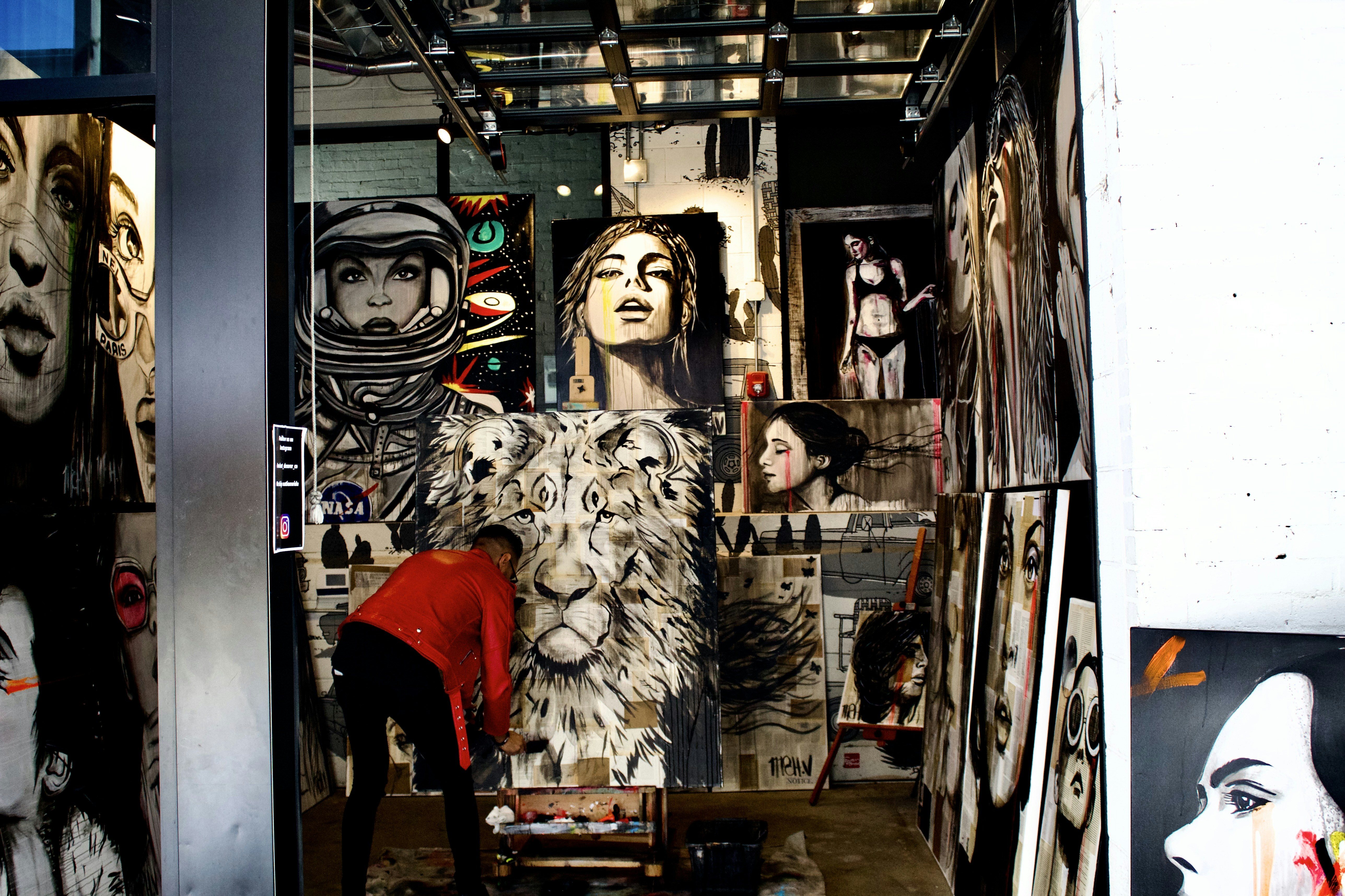 Red-Frocked Figure Amid Monochrome Portraits in a Gallery Studio