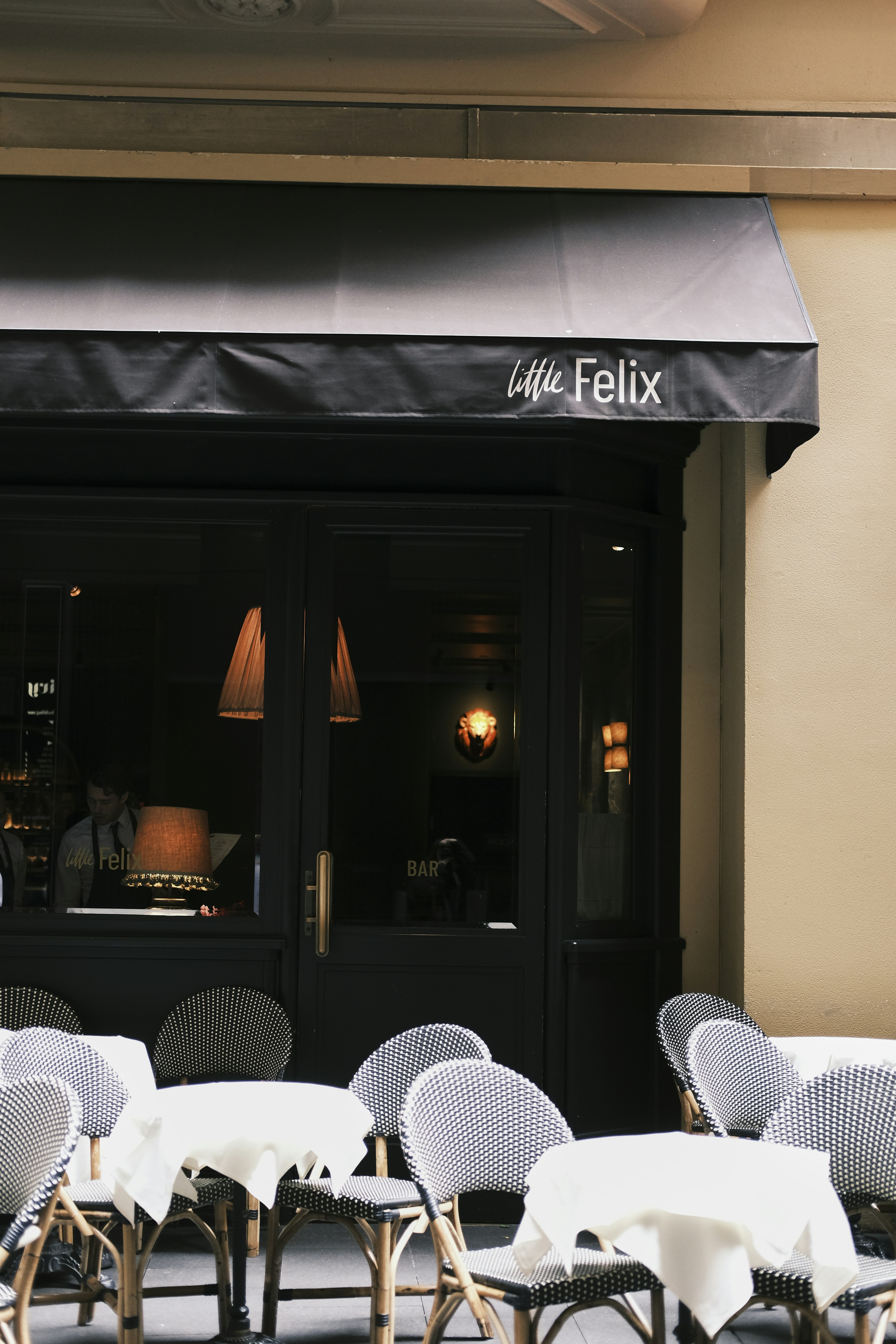 A black door with white tables and chairs in front of it photo – Free ...