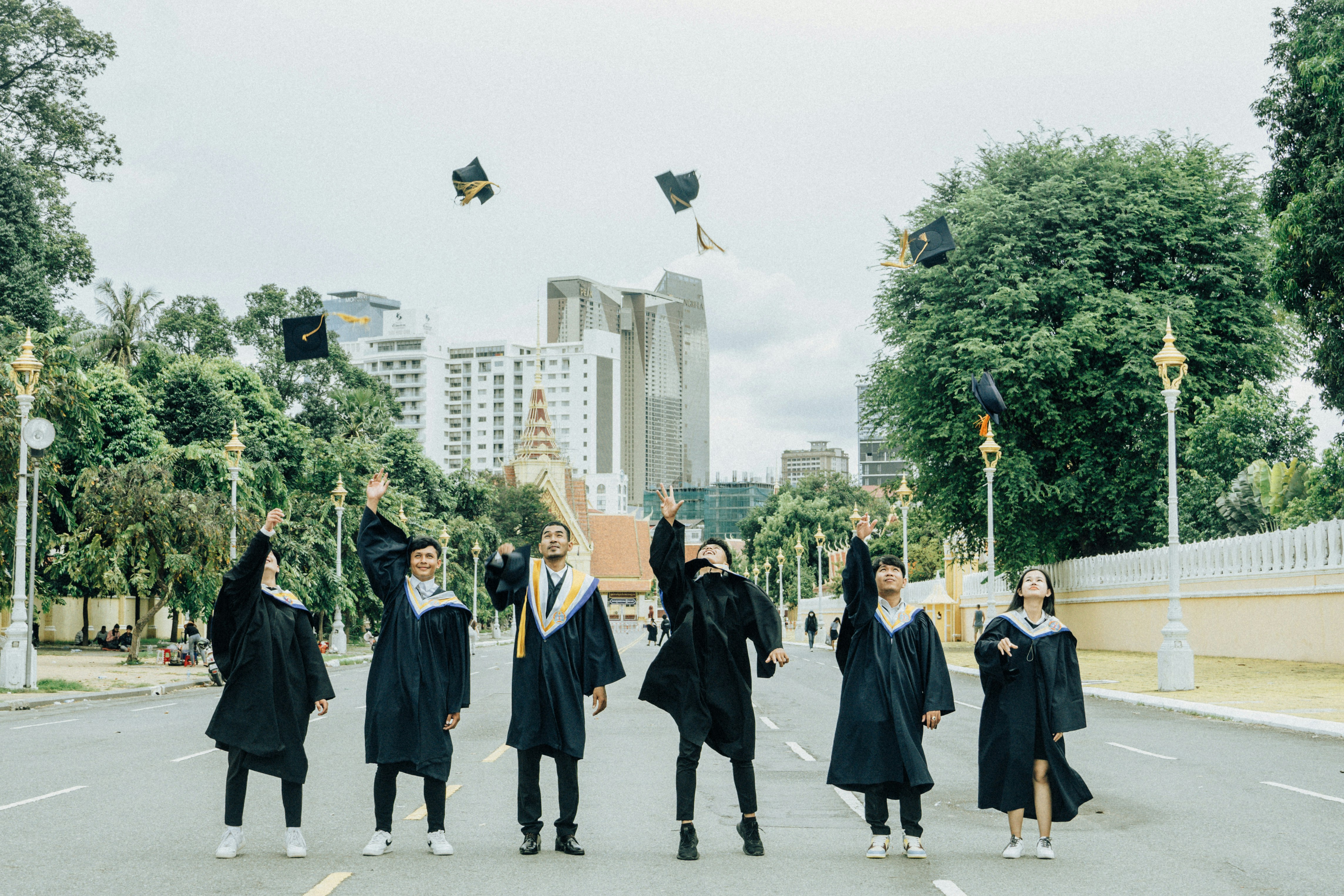 A group of people in graduation gowns flying kites photo – Free ...