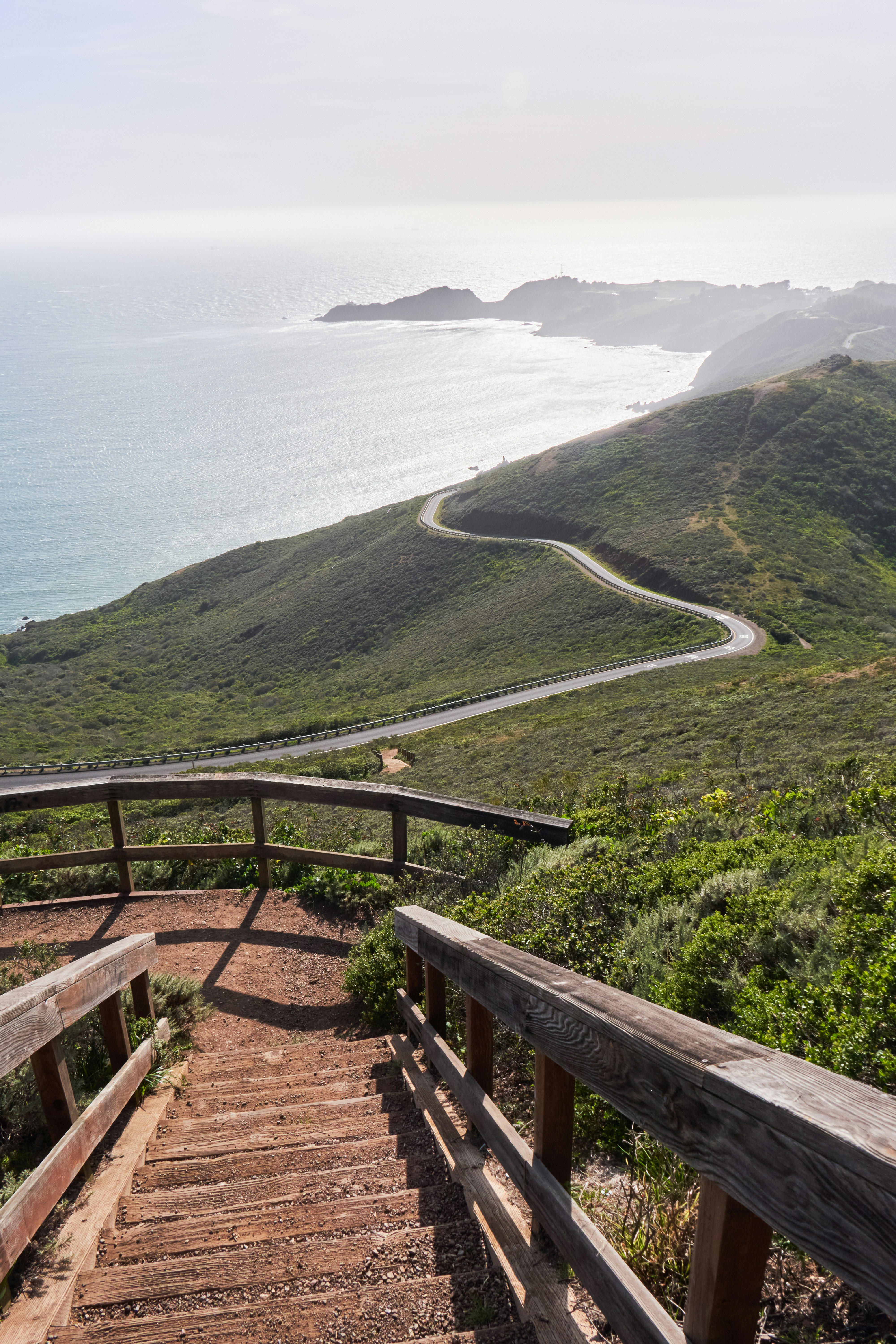 A wooden walkway over a grassy hill overlooking a body of water photo ...