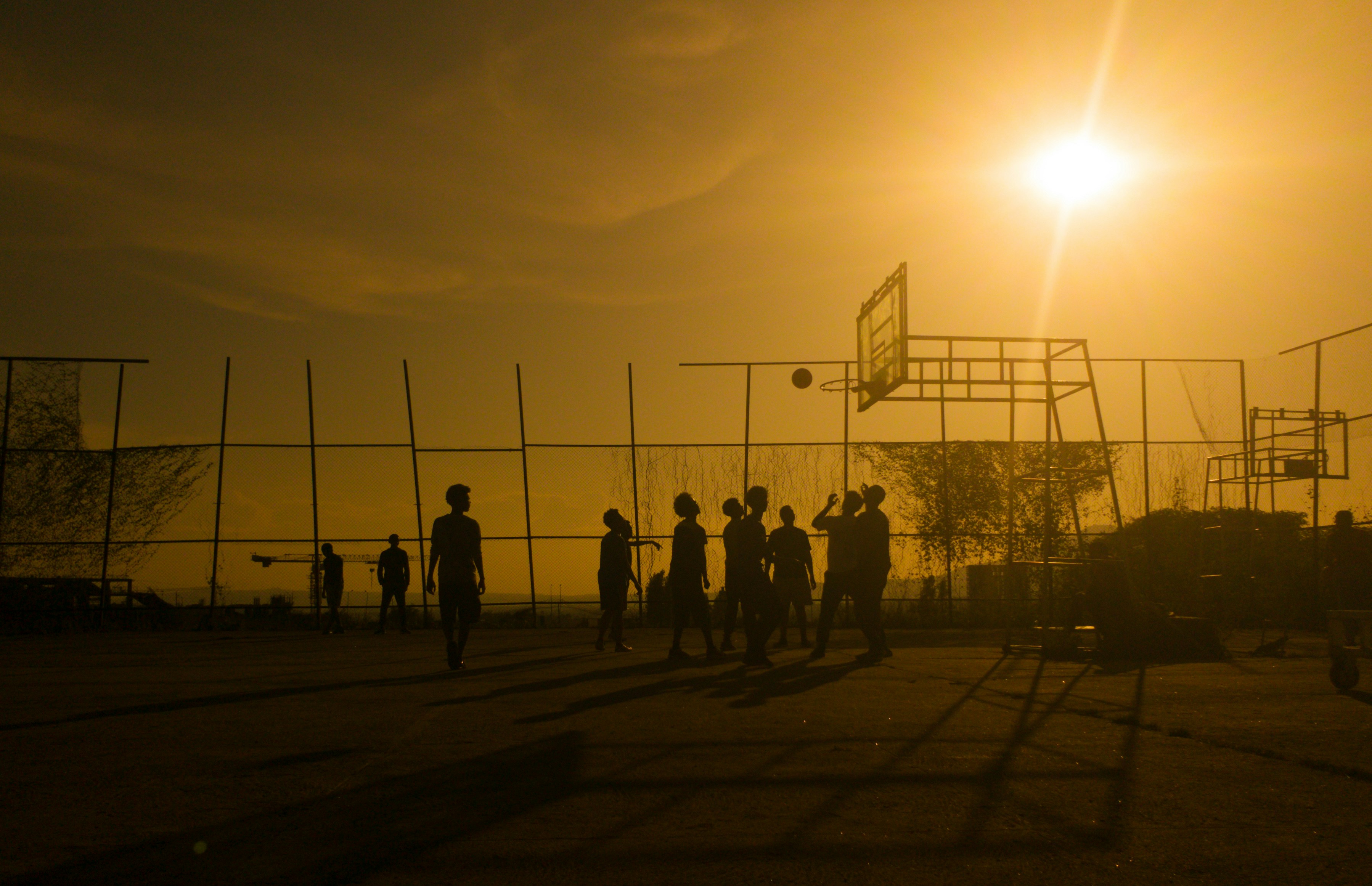 Golden Hour Silhouettes on an Empty Basketball Court