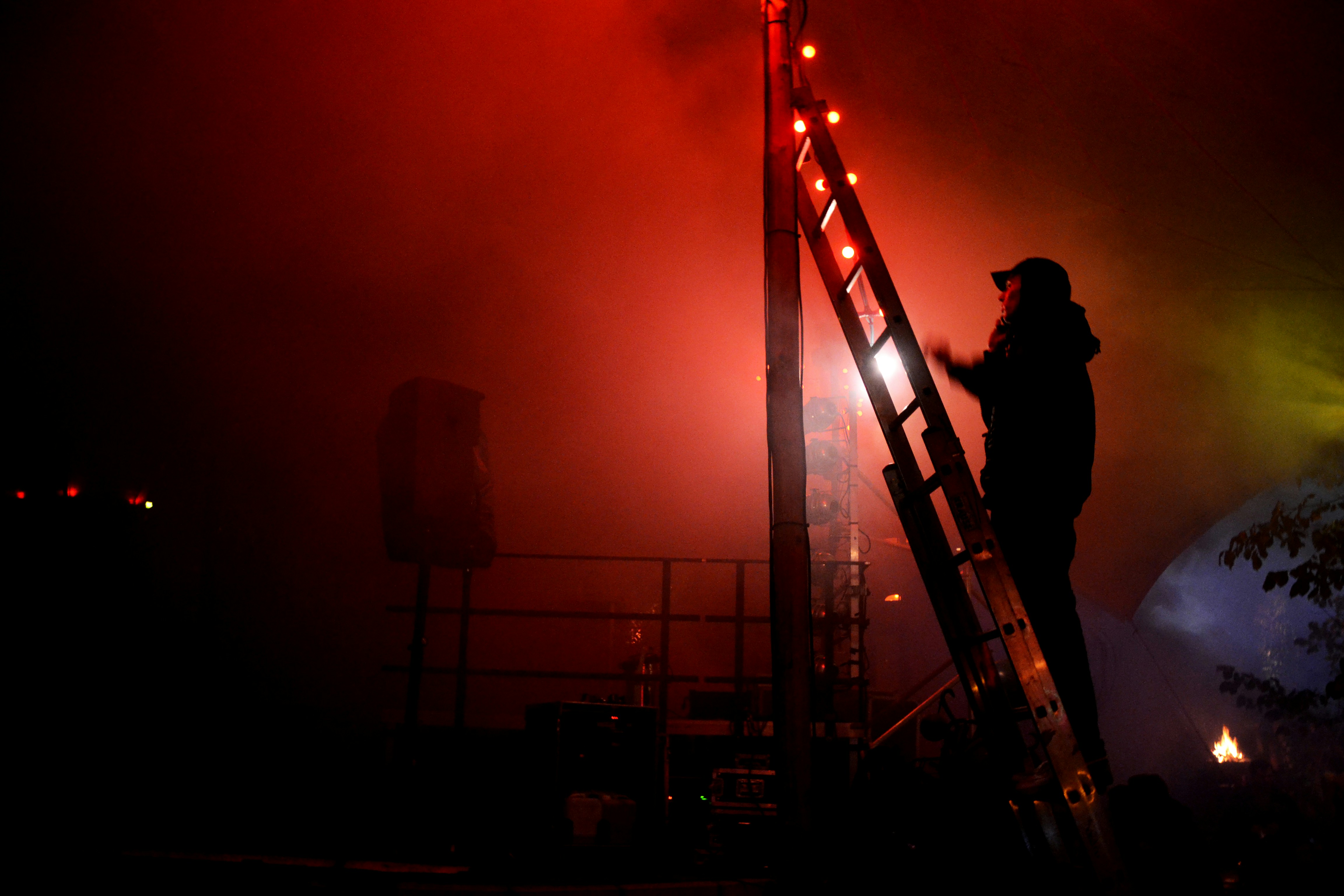 Crimson Ascent: Silhouetted Climber Beneath Smoky Red Lights