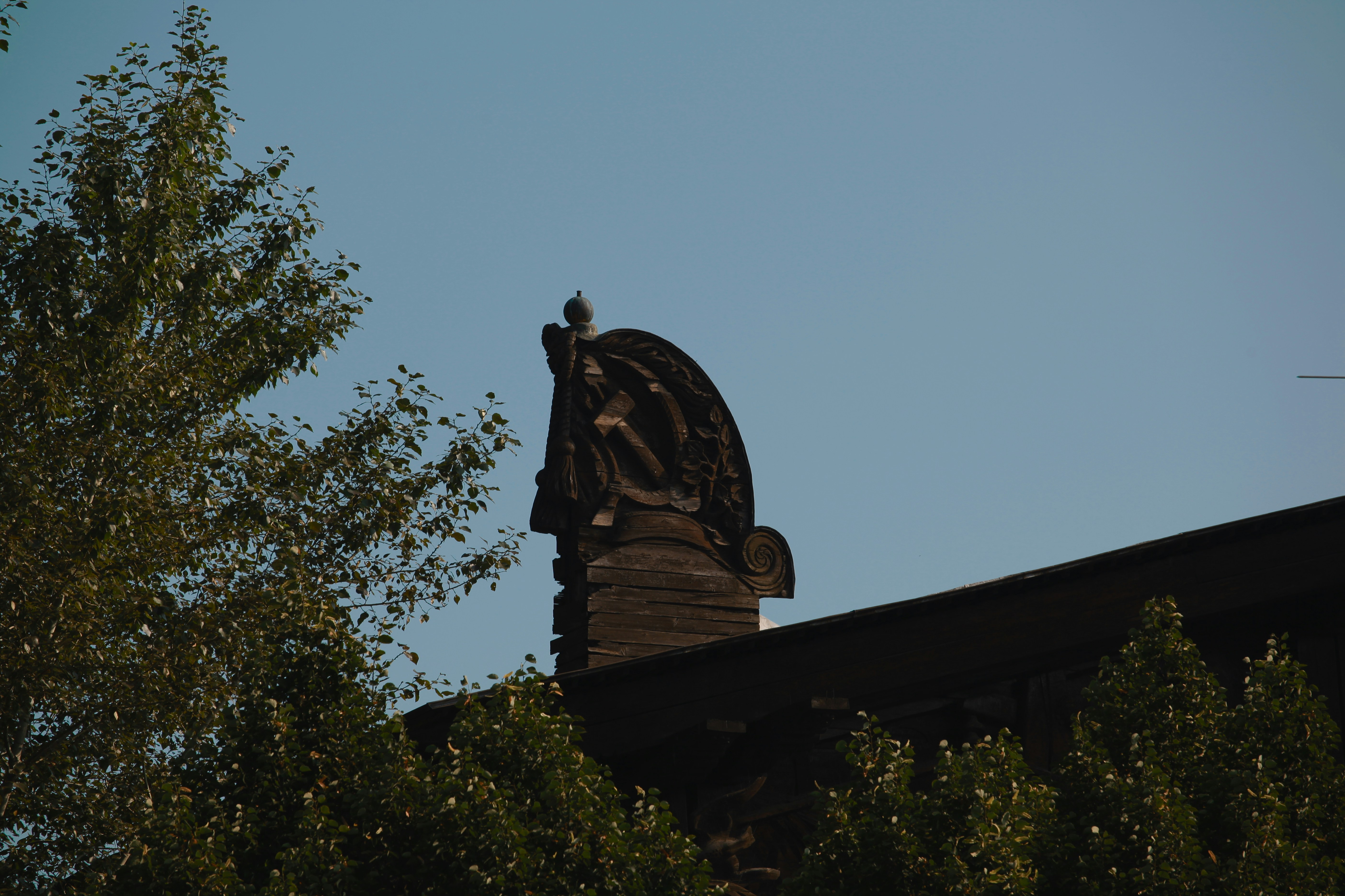 Stone Carved Warrior Crowning the Rooftop Ridge