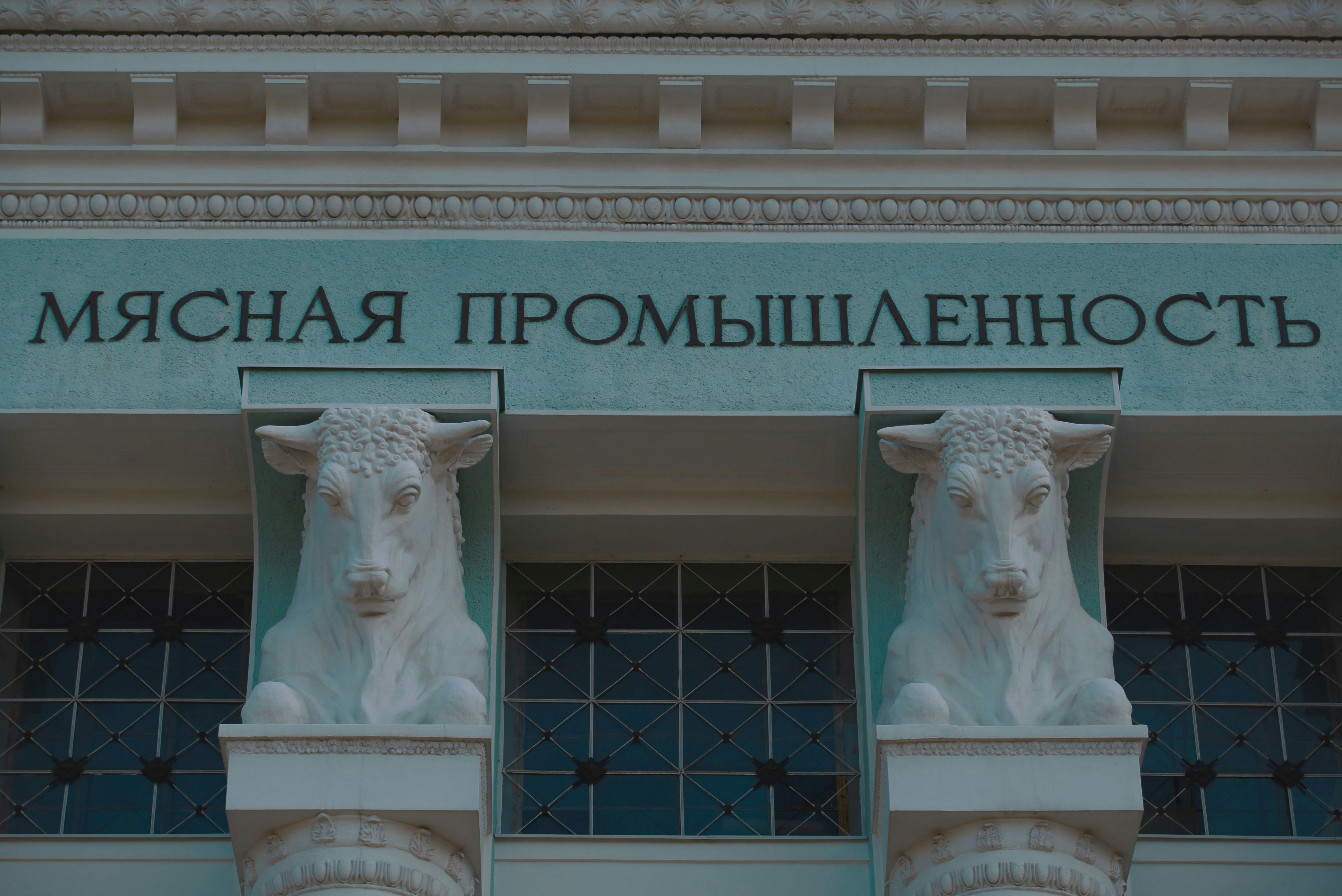 Guardians of the Meat Industry: Twin Bull Statues Frame a Teal Facade