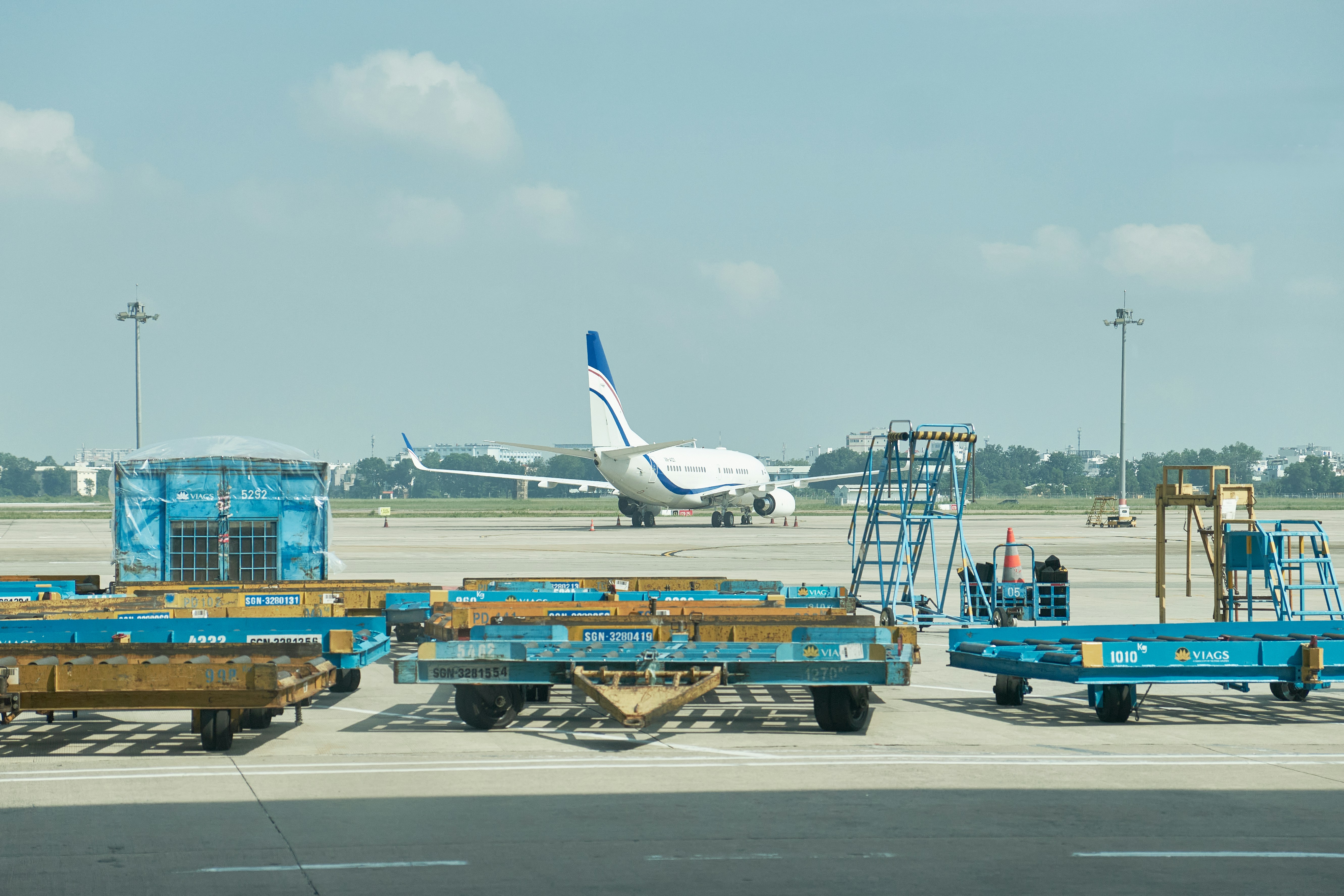 Toward the Runway: A Quiet Apron Scene with a Distant Jet
