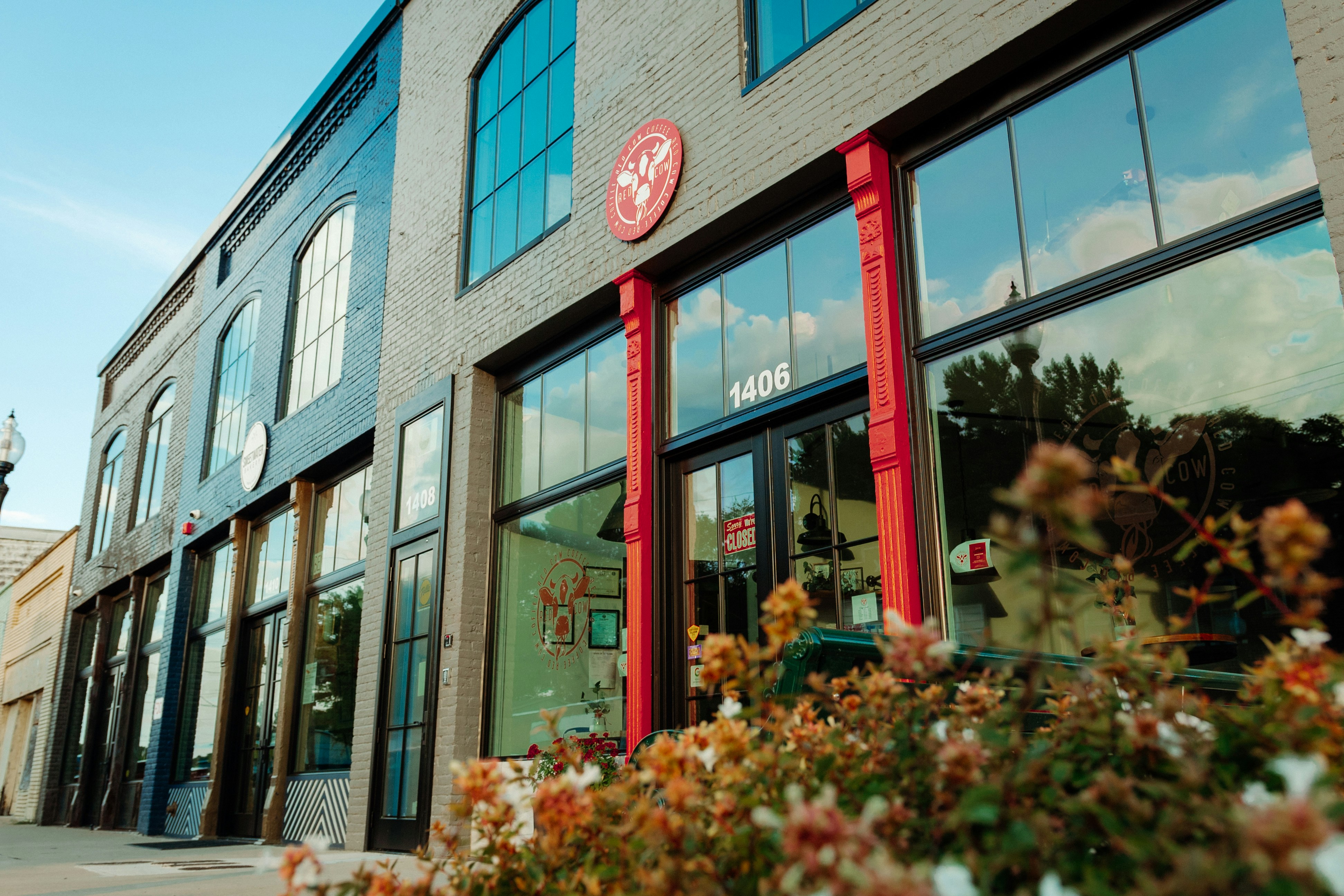 Crimson Columns Framing a Sunlit Row of Glass-Front Shops