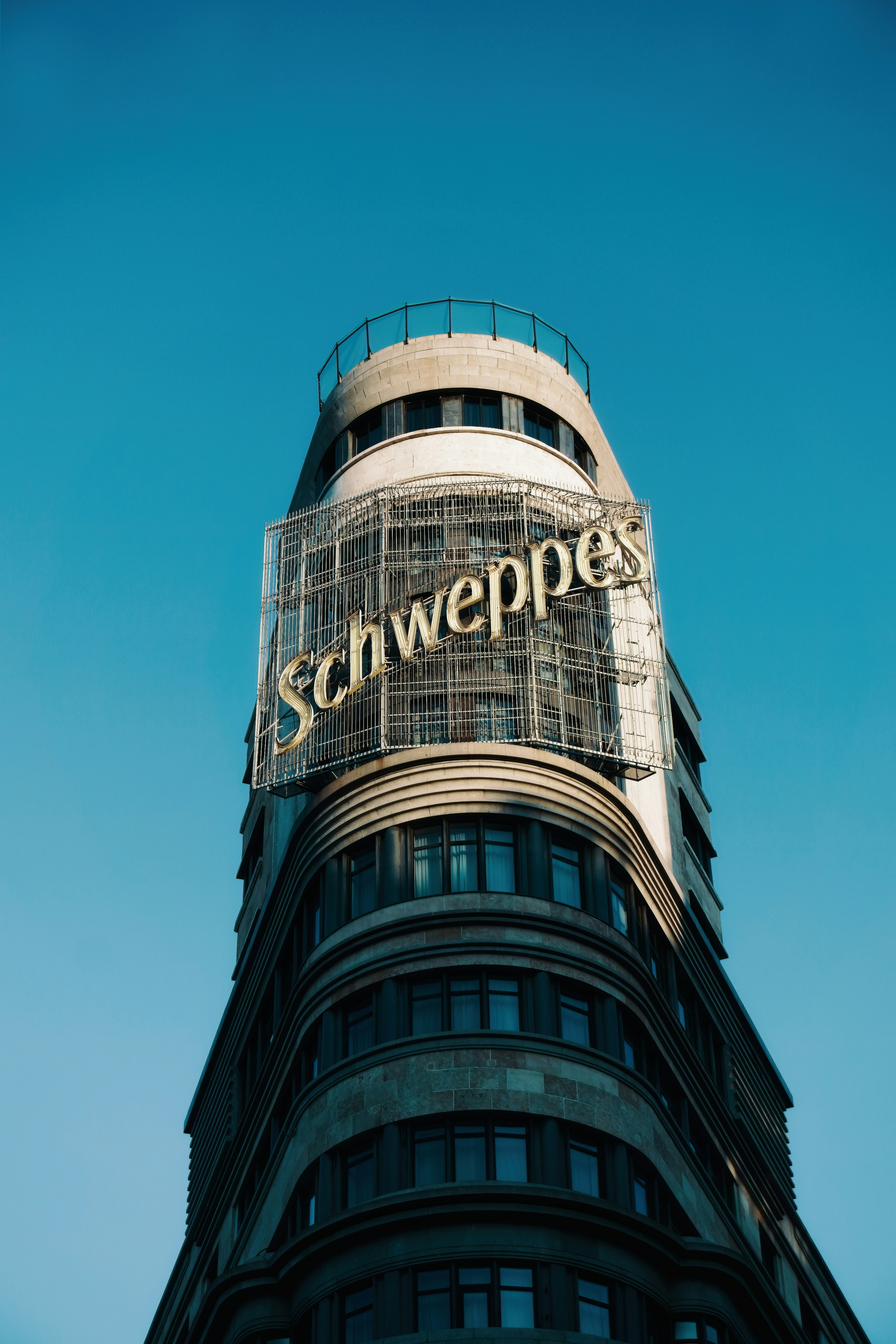 Towering Schweppes Sign on a Curved Modernist Facade