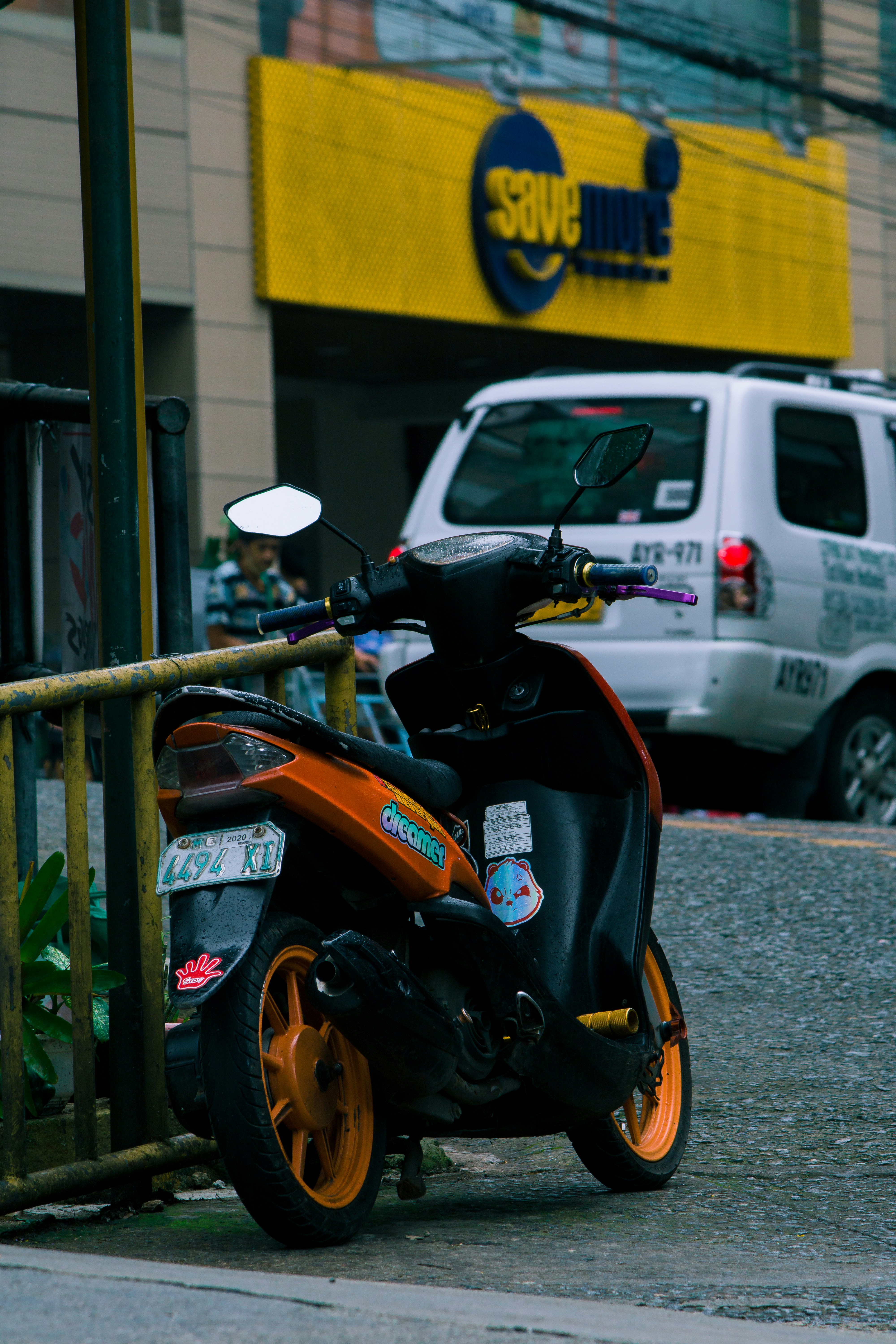 Sunset-Orange Scooter by a Rail, Under a Bright Yellow Storefront