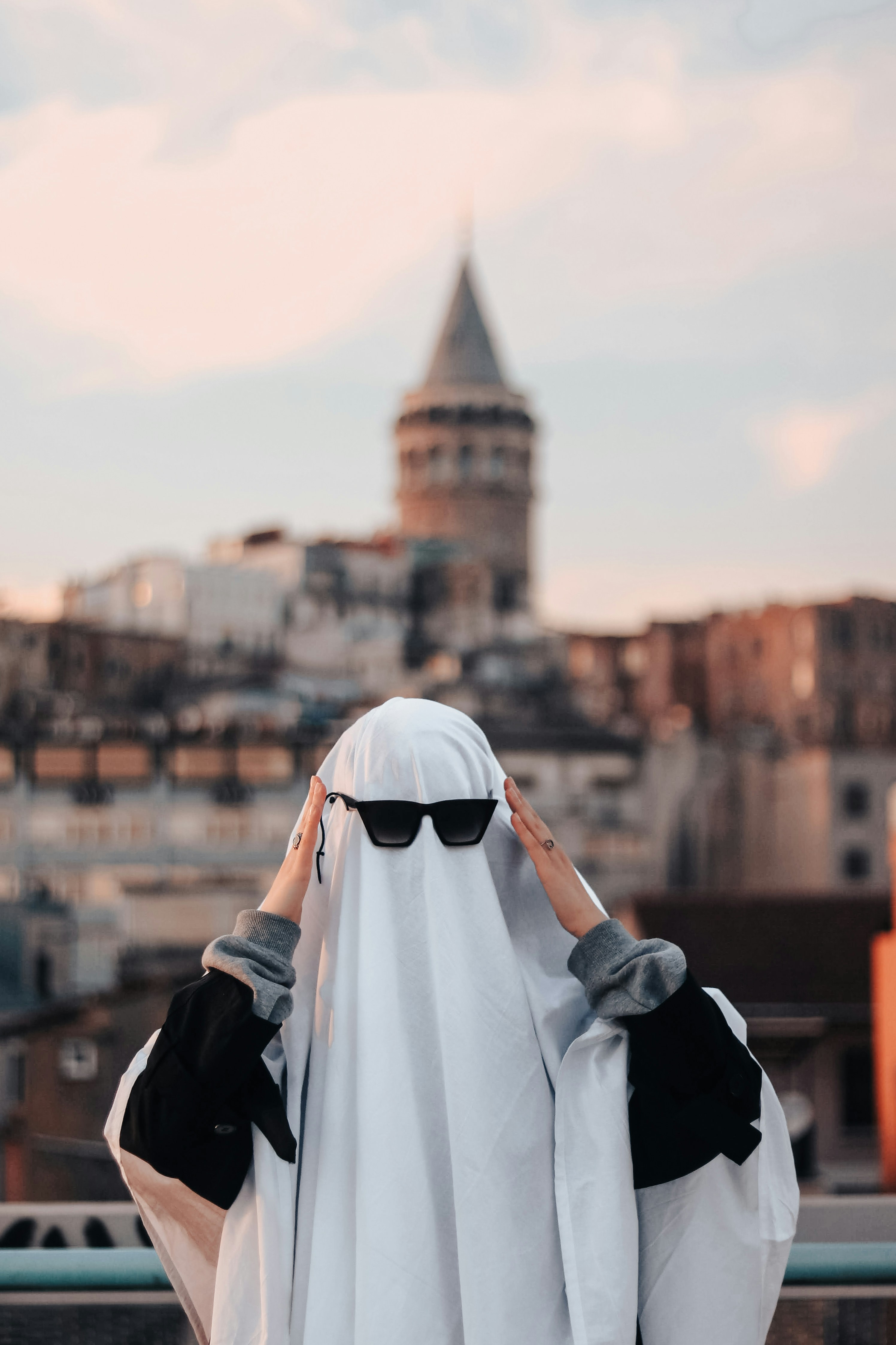 A person wearing a white robe and sunglasses with a building in the ...