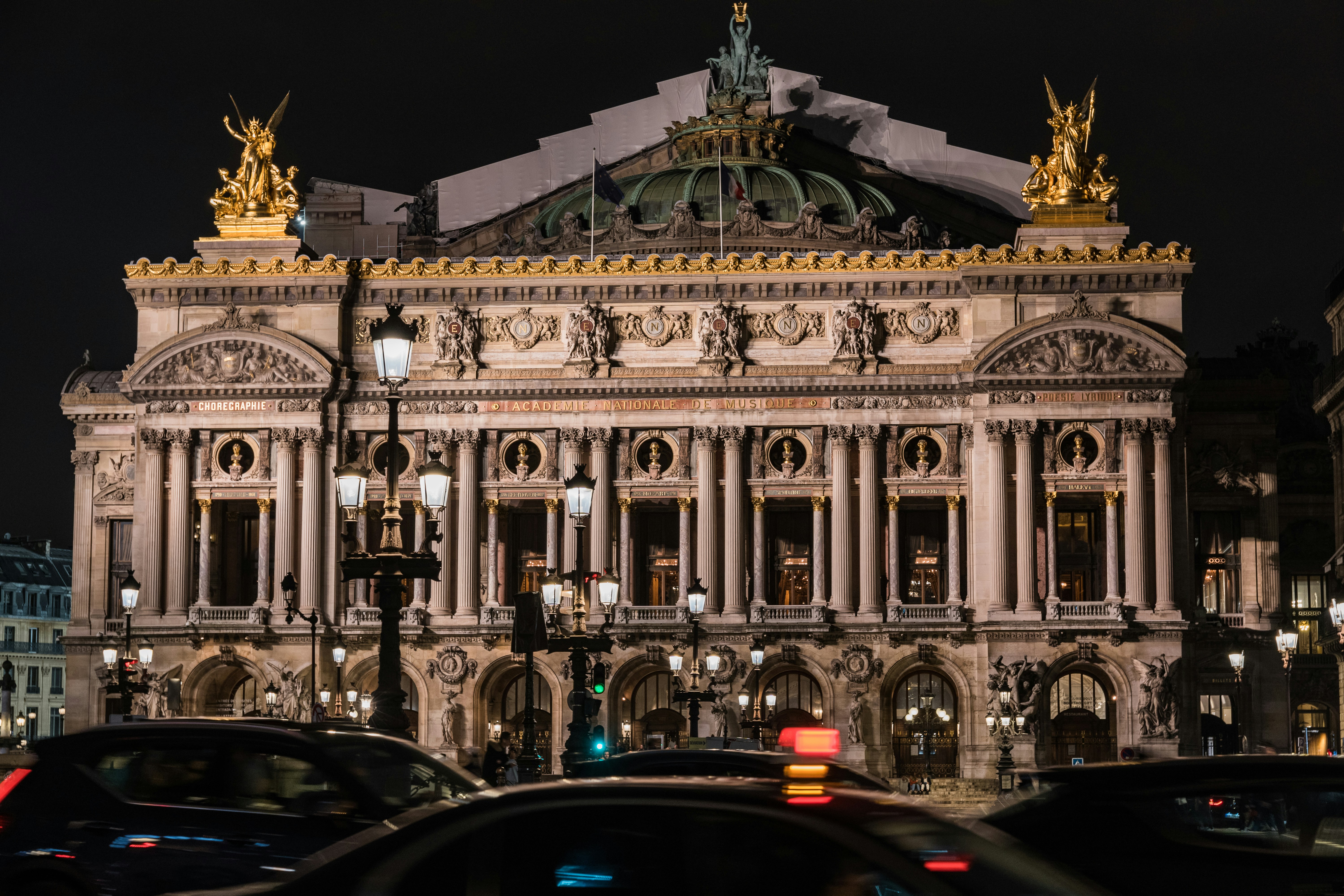 A large building with columns and statues with Palais Garnier in the ...