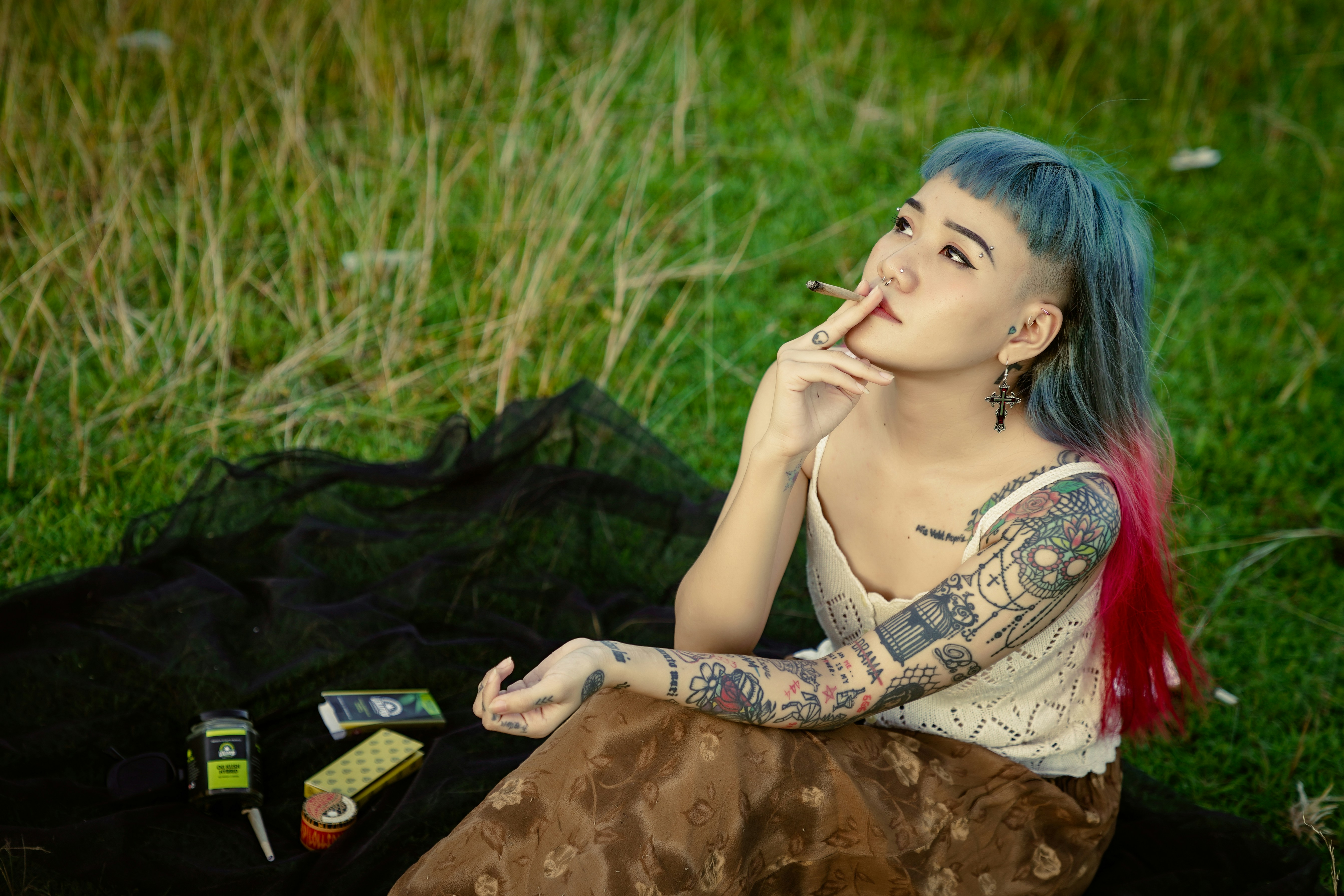 A person sitting on the ground smoking a cigarette photo – Free Woman ...