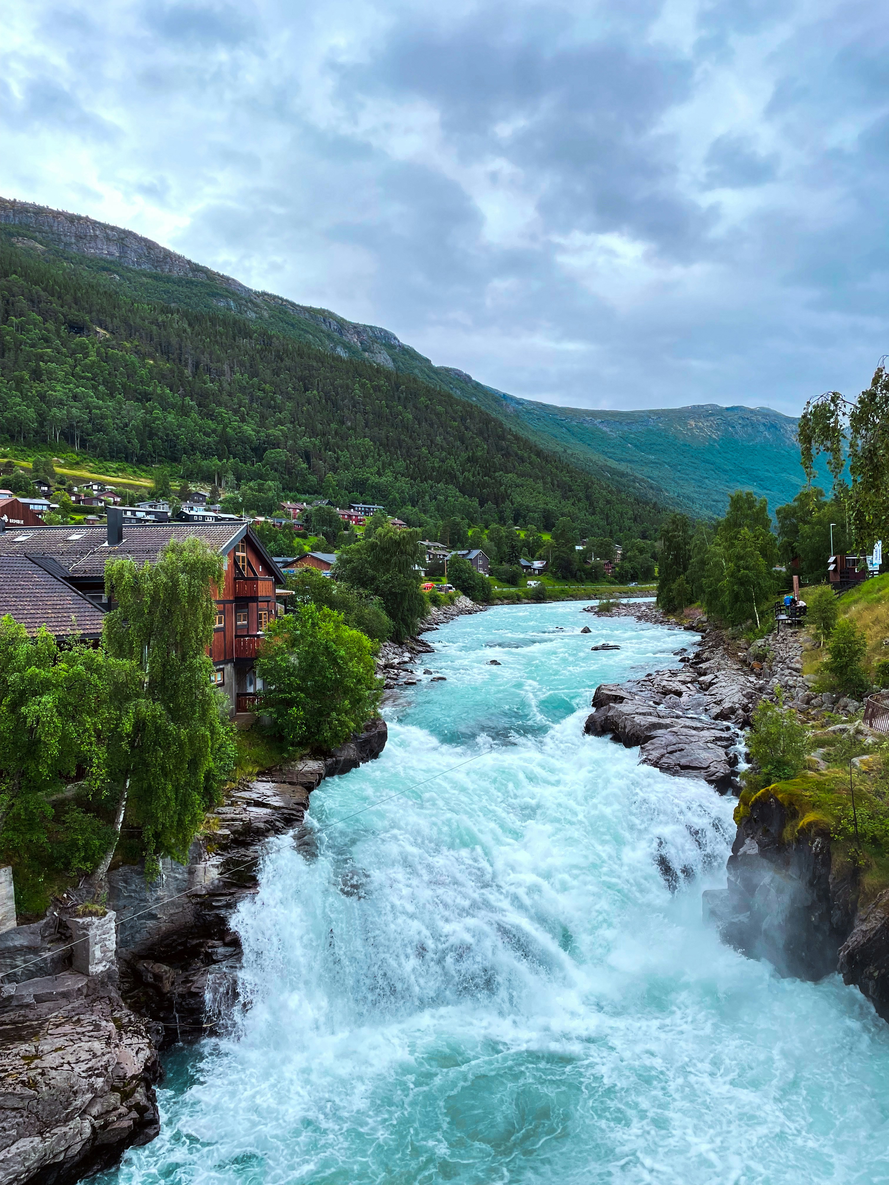 Turquoise Rapids Winding Through a Nordic Village