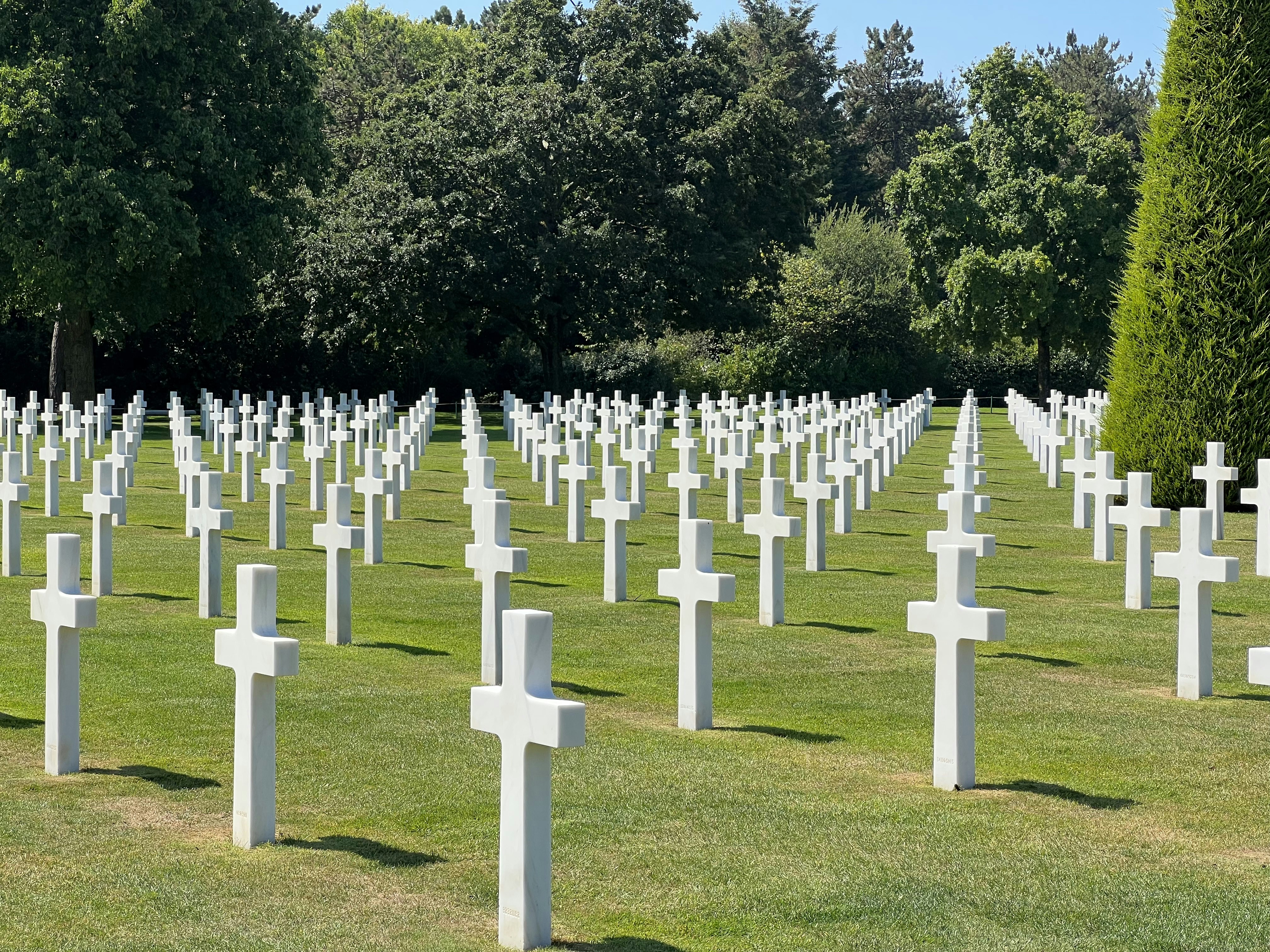 A cemetery with many white crosses with Arlington National Cemetery in ...