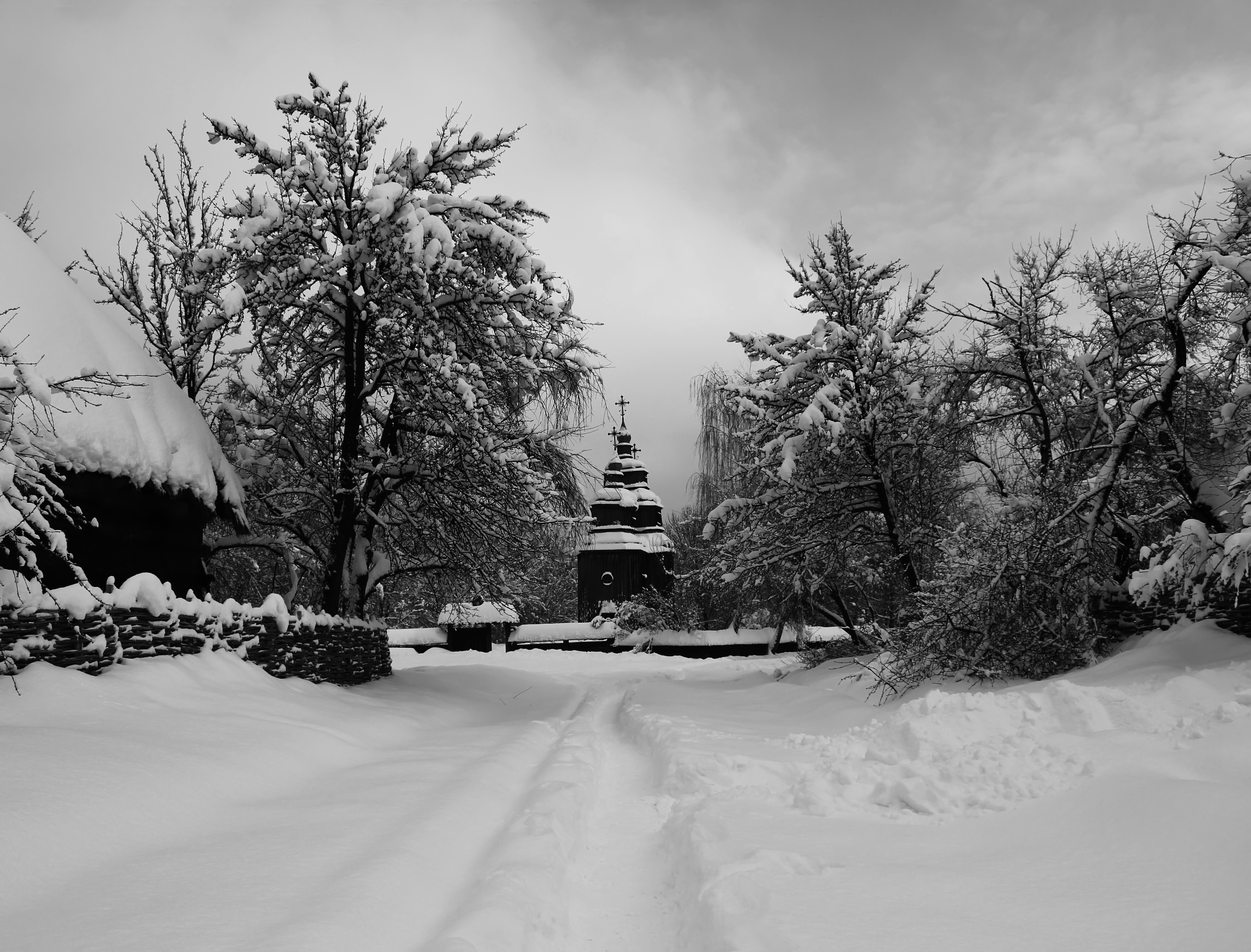 Snowbound Lane Toward a Clock-Towered Chapel