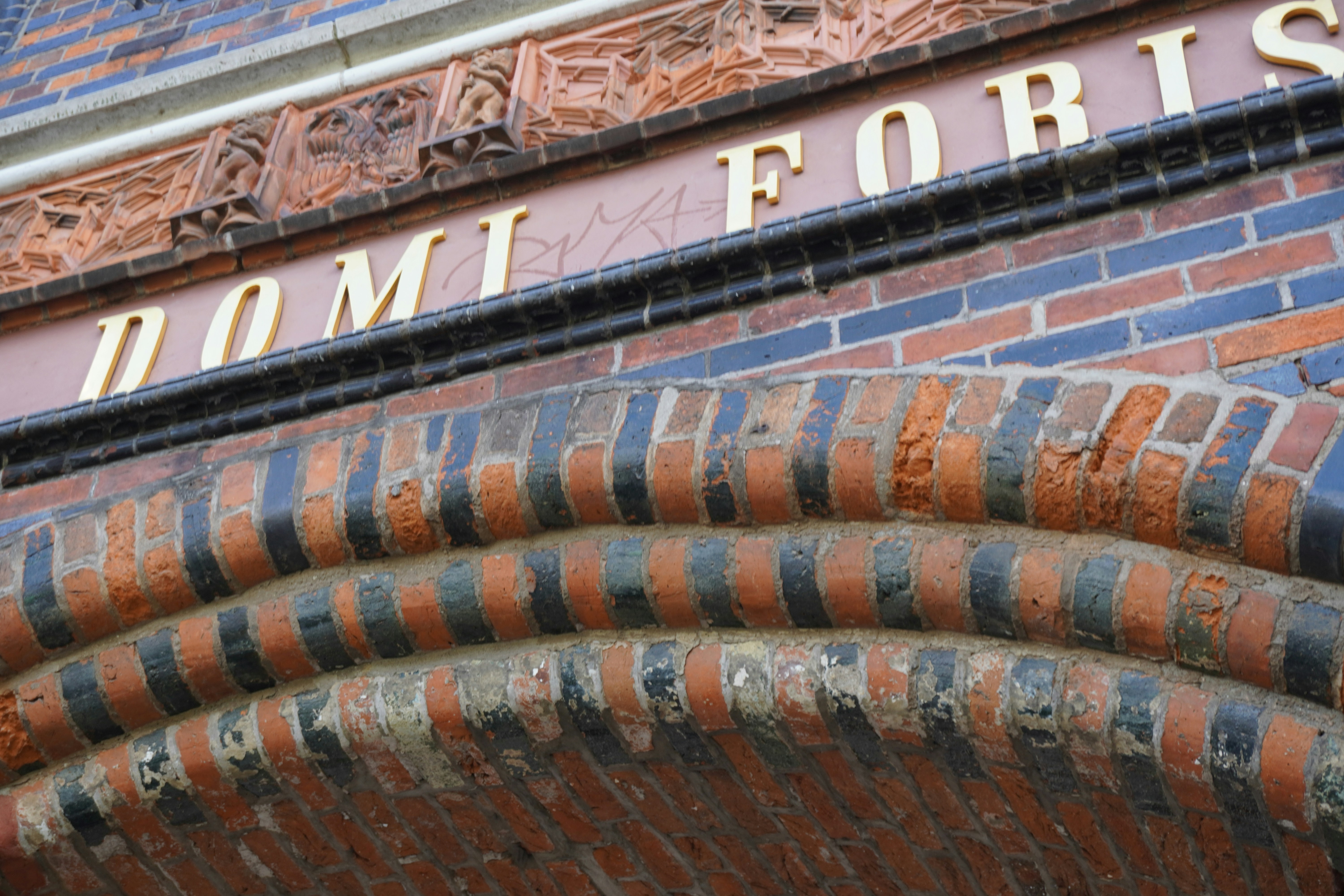 Gold Lettering over a Weathered Brick Archway