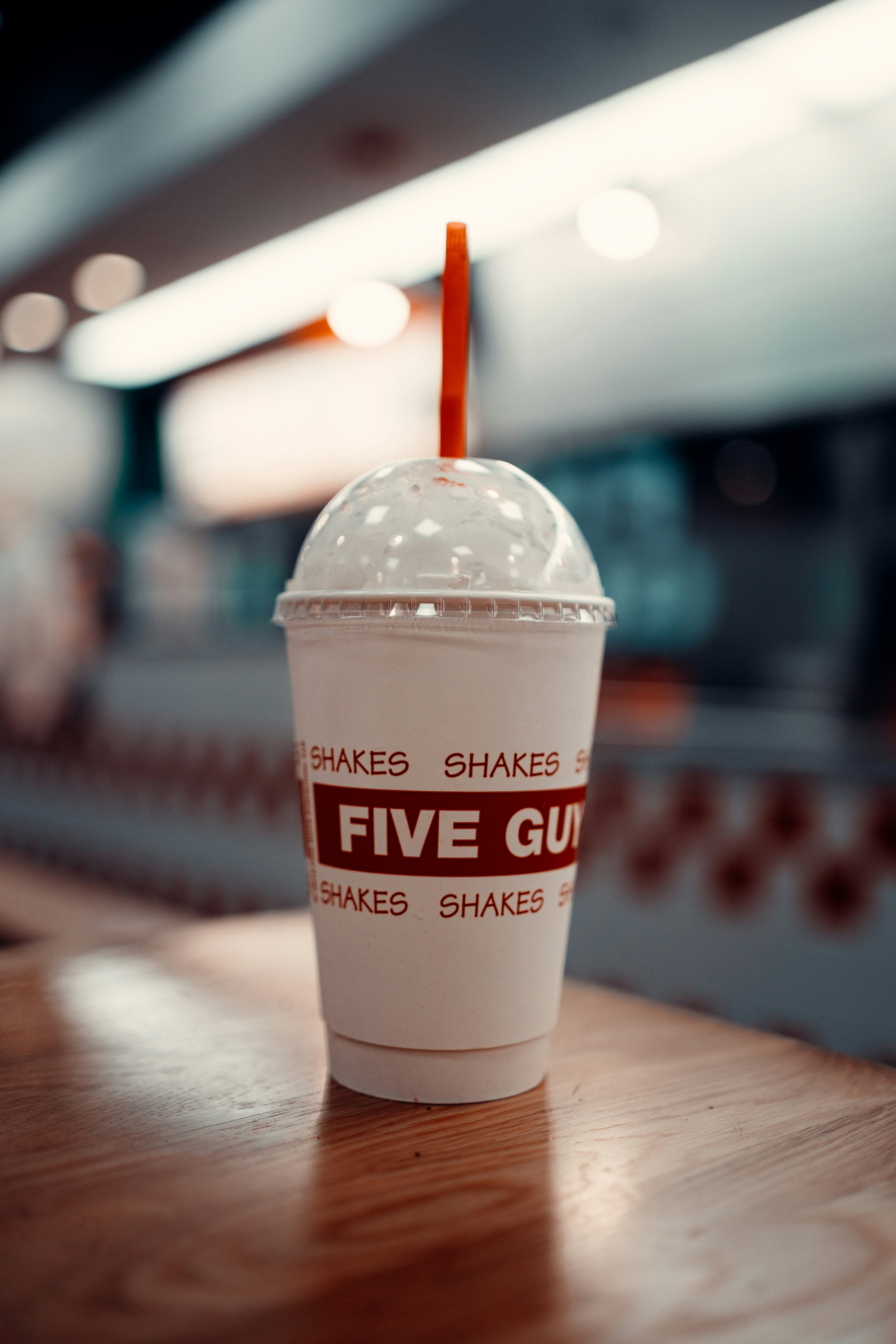Red Straw Constellation: A Five Guys Milkshake Anchored on a Neon-Soaked Counter