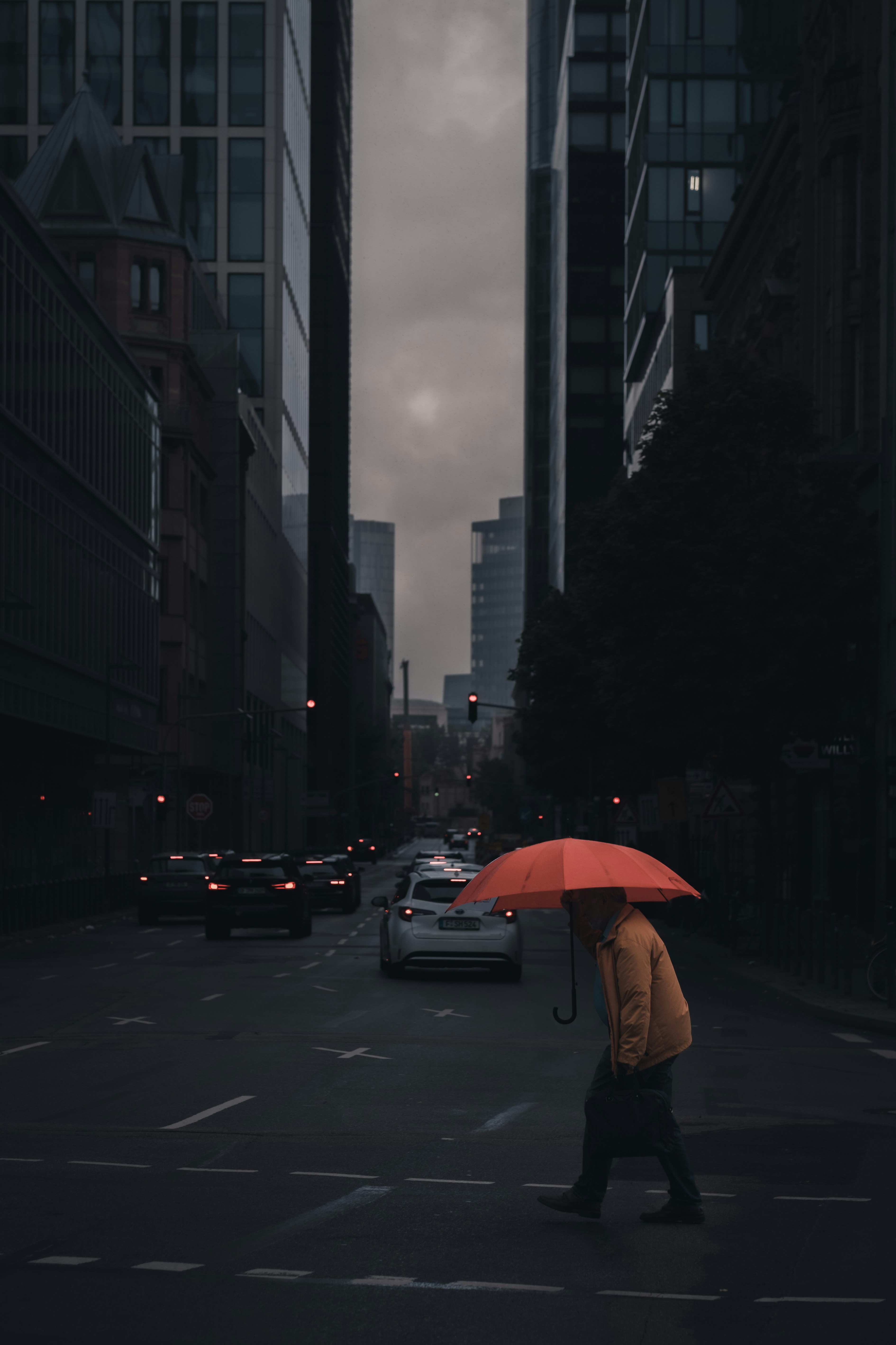 Red umbrella crossing street.