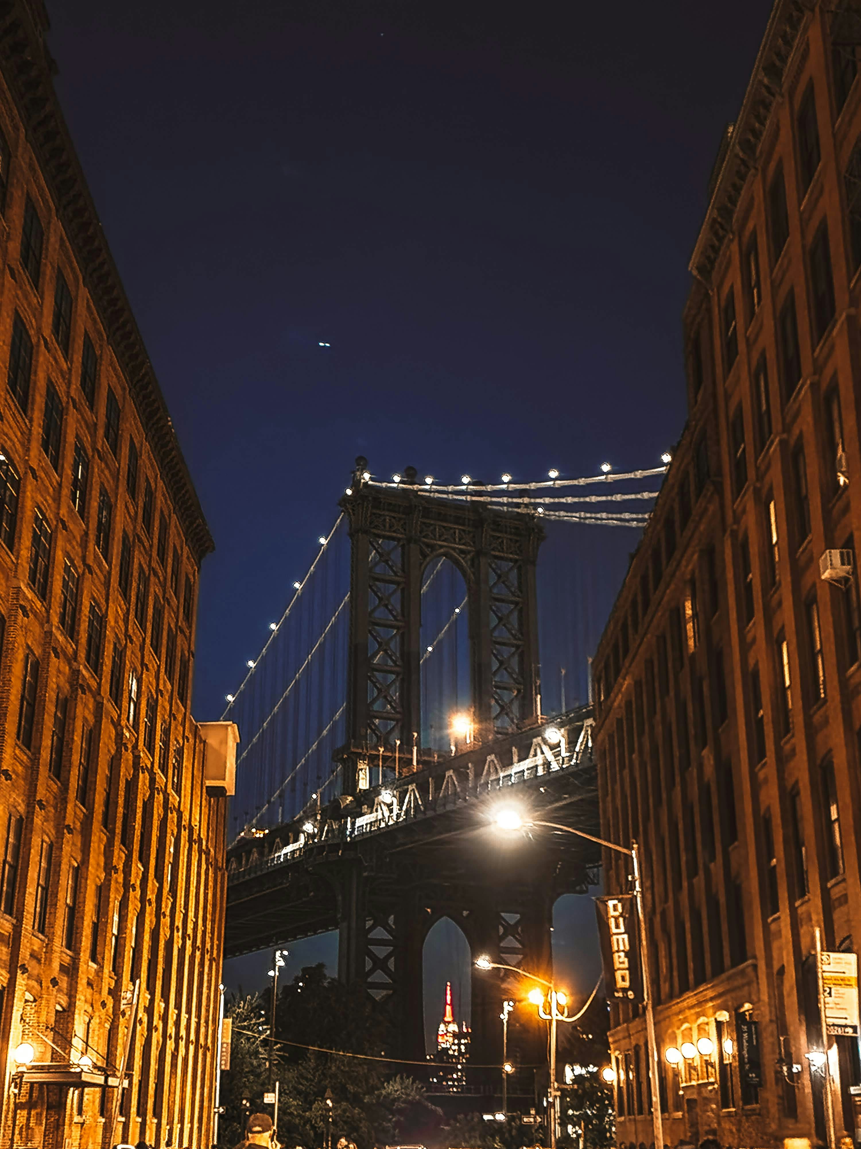 Between Brick Giants: Night Walk Toward the Looming Suspension Tower