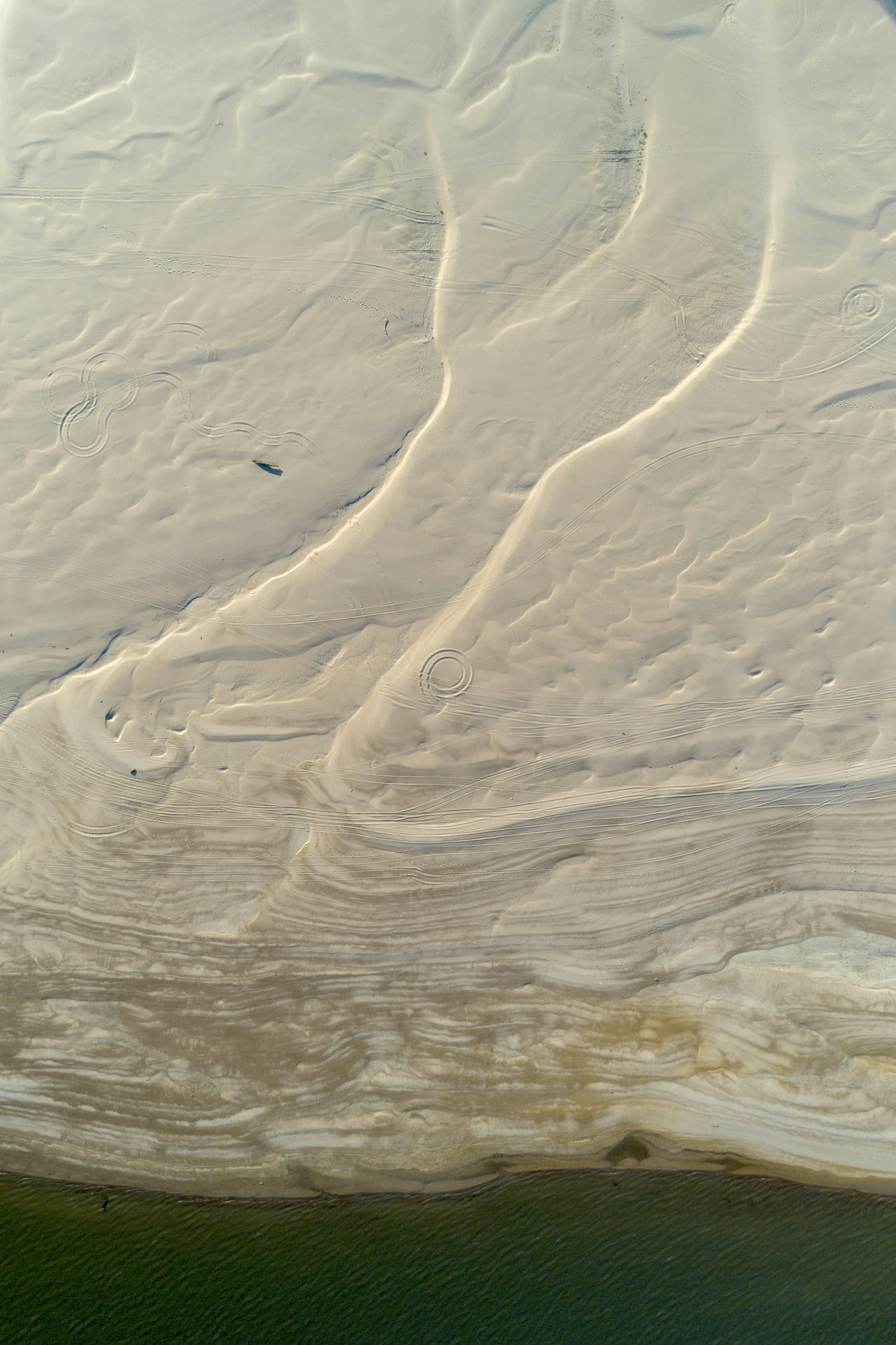 Whispered Lines: Wind-Carved Dunes Meet a Narrow Waterline