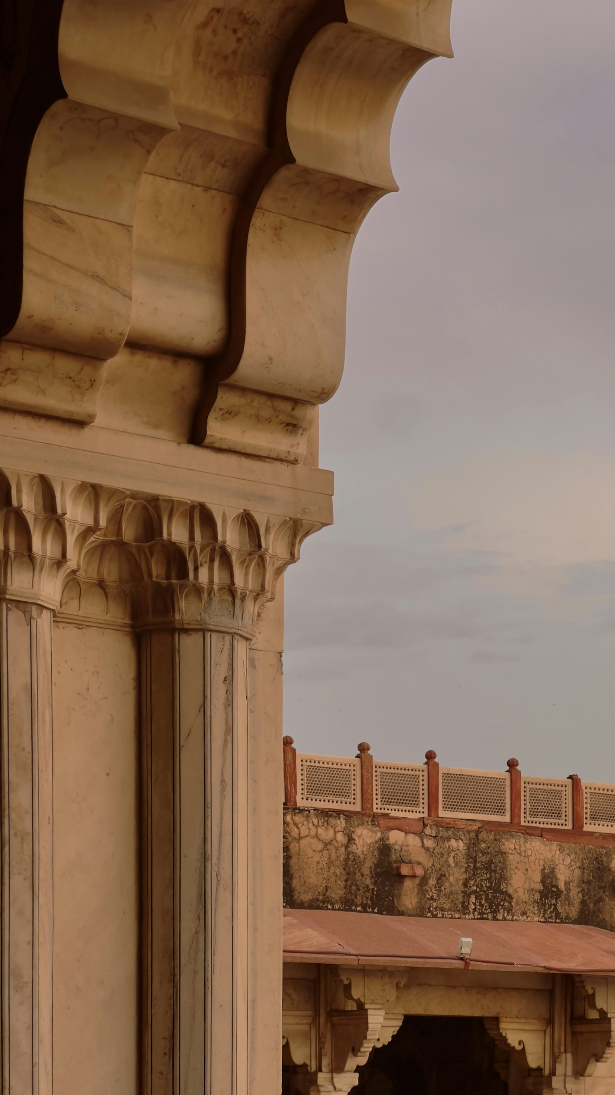 Intricate marble columns frame a view of a historic courtyard, capturing the essence of architectural elegance and cultural heritage.