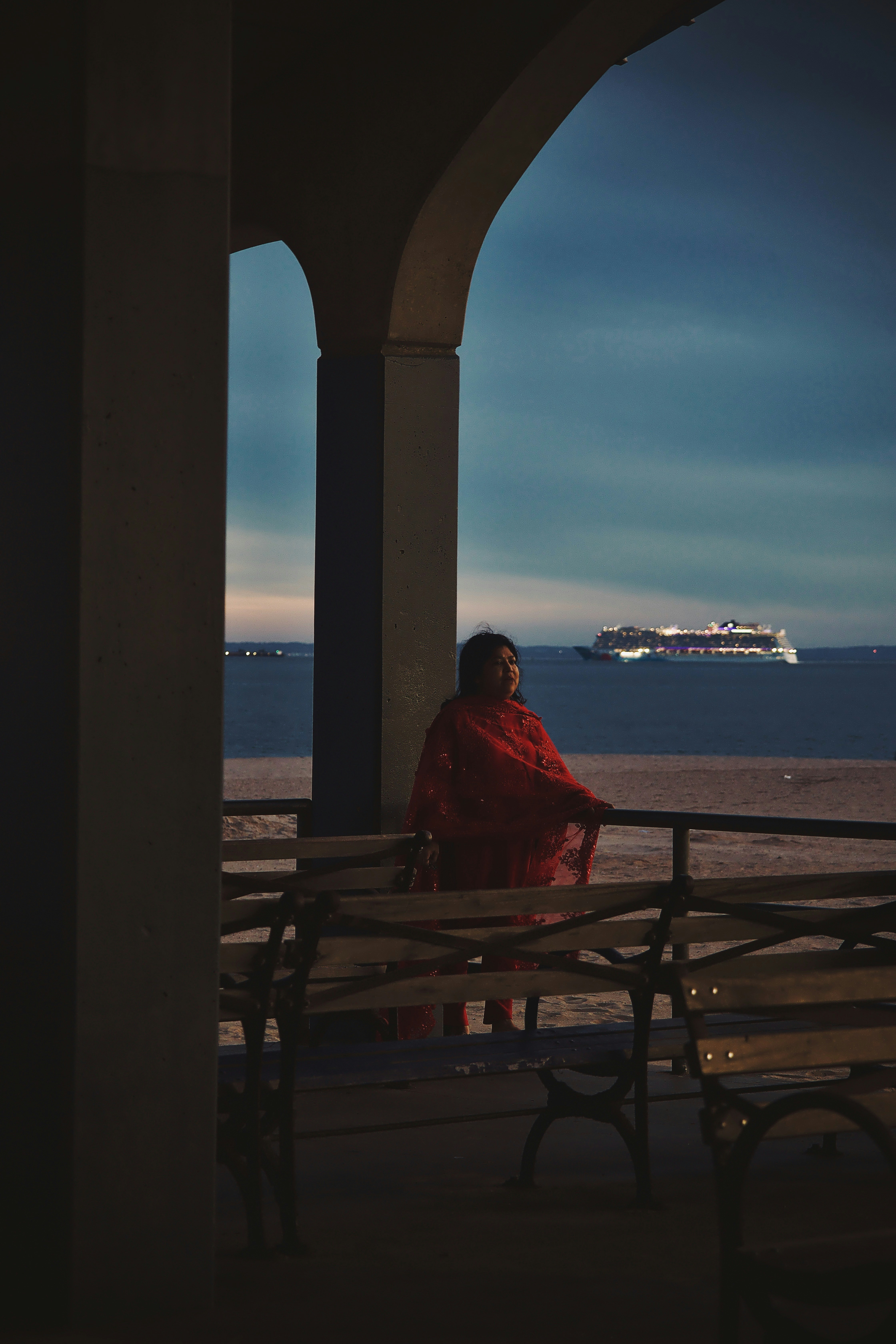 Red Shroud by the Sea: Blue Hour Moment Under the Arched Terrace