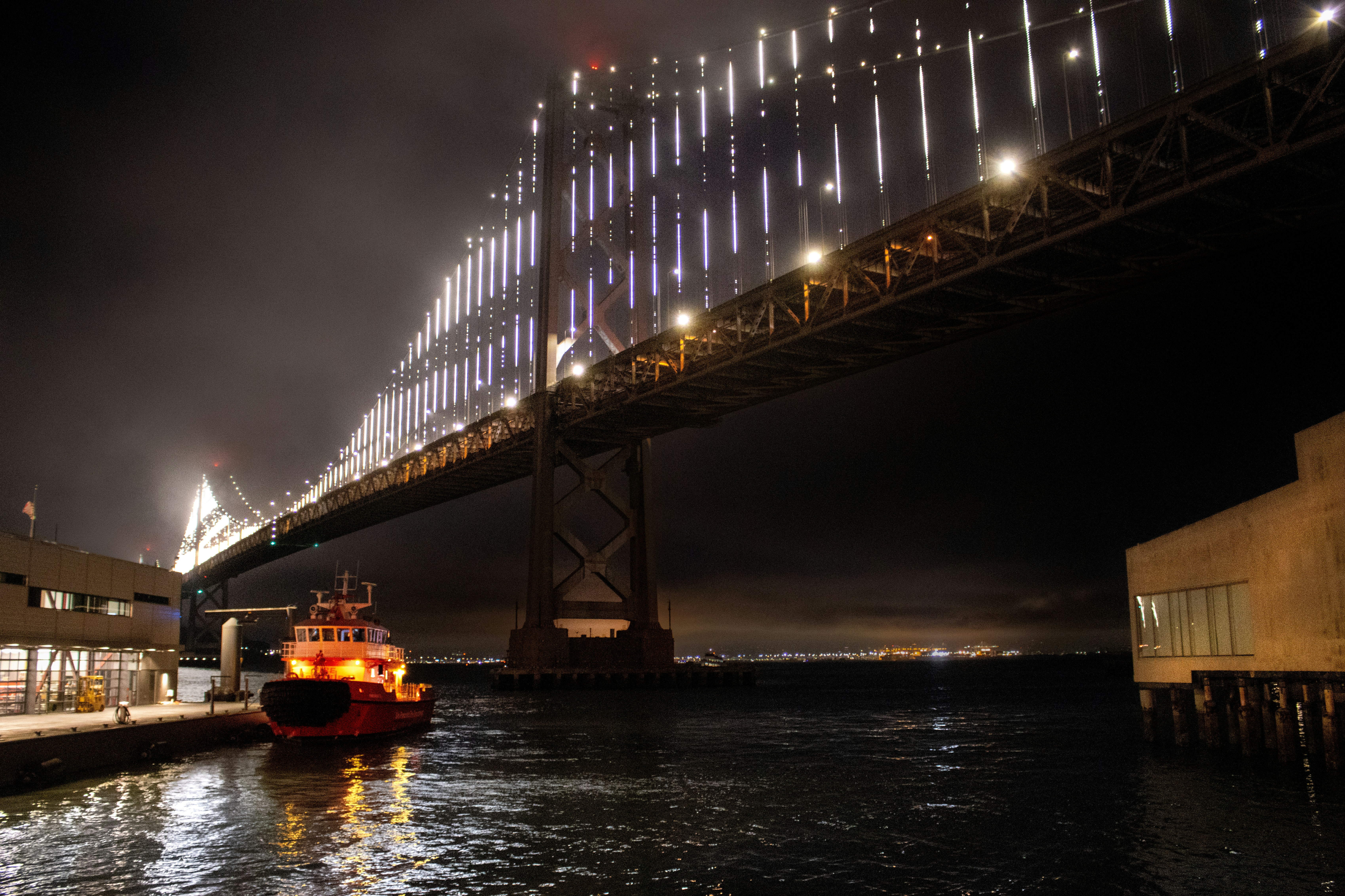 Glowing Span, Quiet Harbor: A Night Tug Beneath the Beaming Bridge