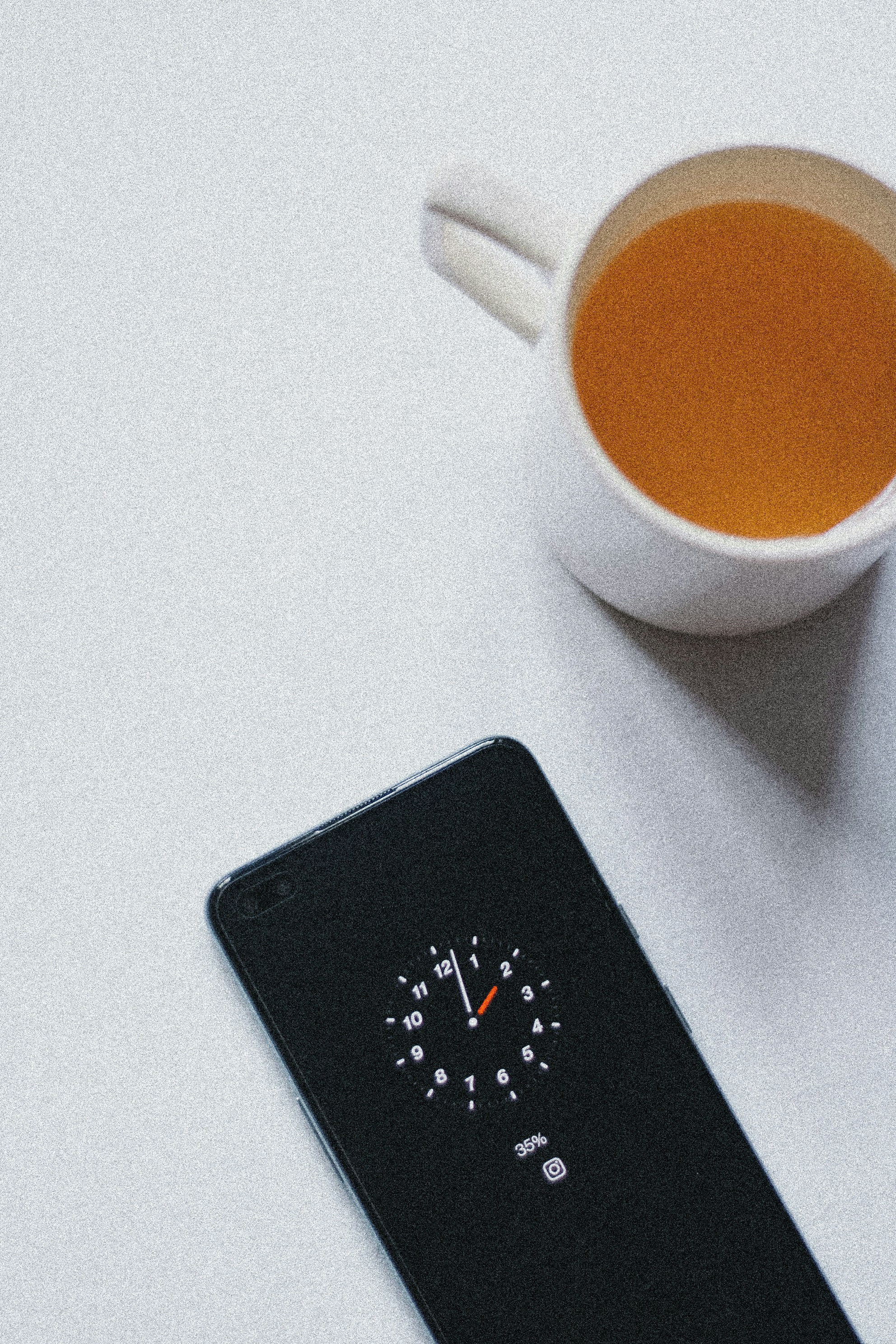Calm Morning On a Table: A Smartphone and a Mug Beside a Slow-Ticking Watch