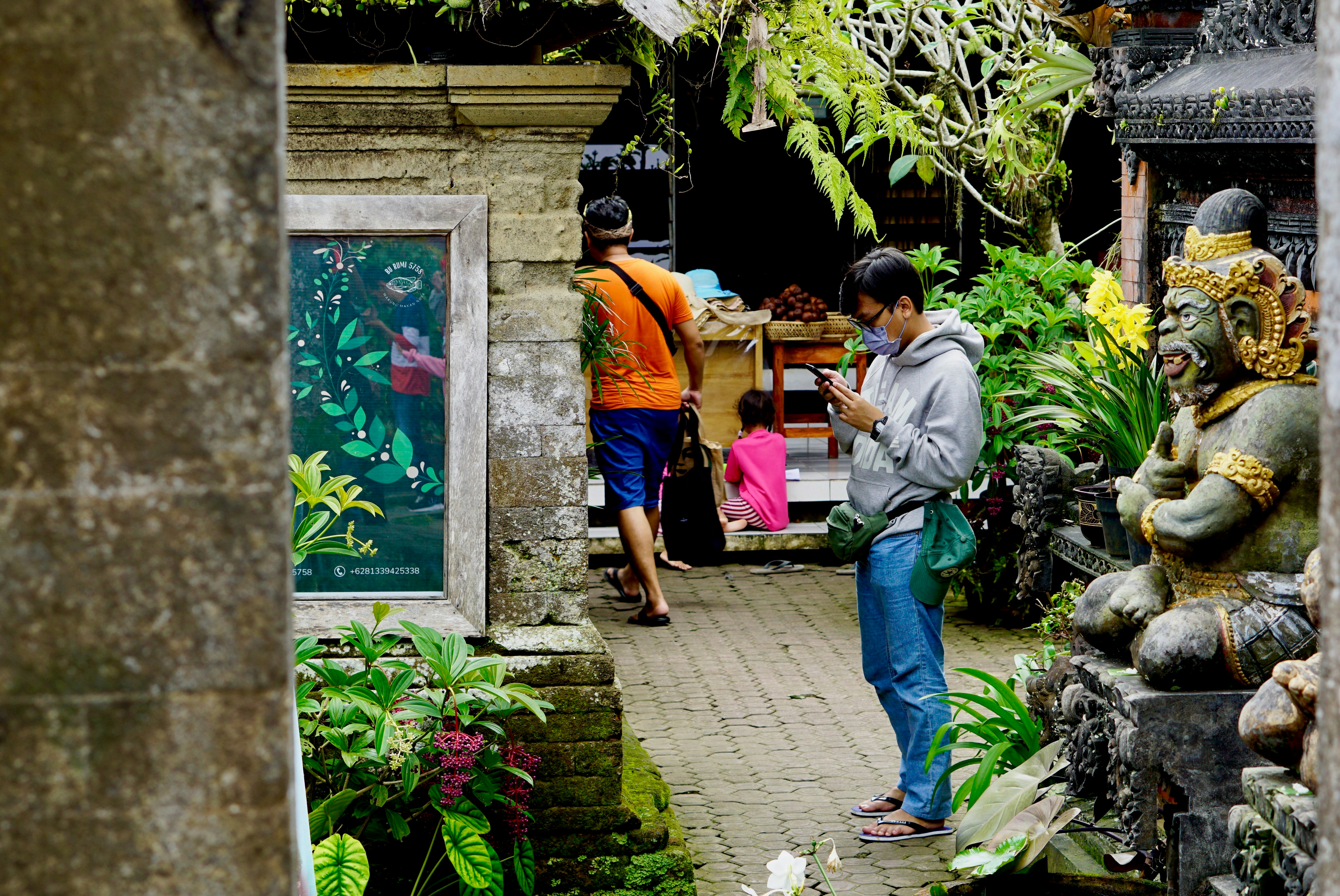 A Quiet Shrine Corridor: Tourists and a guardian statue
