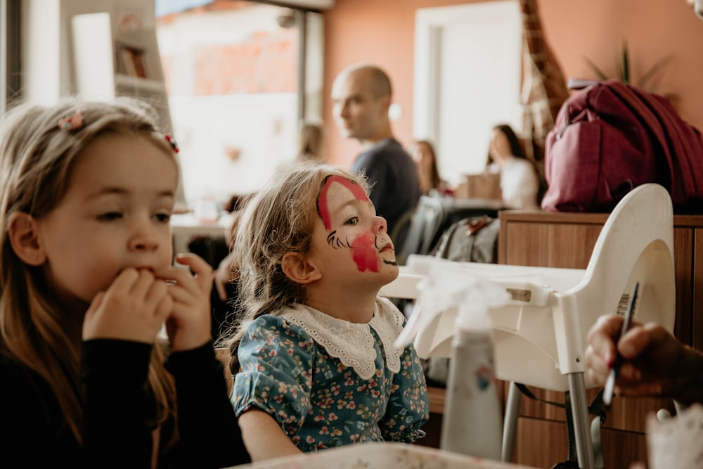 Un couple de jeunes filles assises à une table avec un papier et un ... Un couple de jeunes filles assises à une table avec un papier et un ...