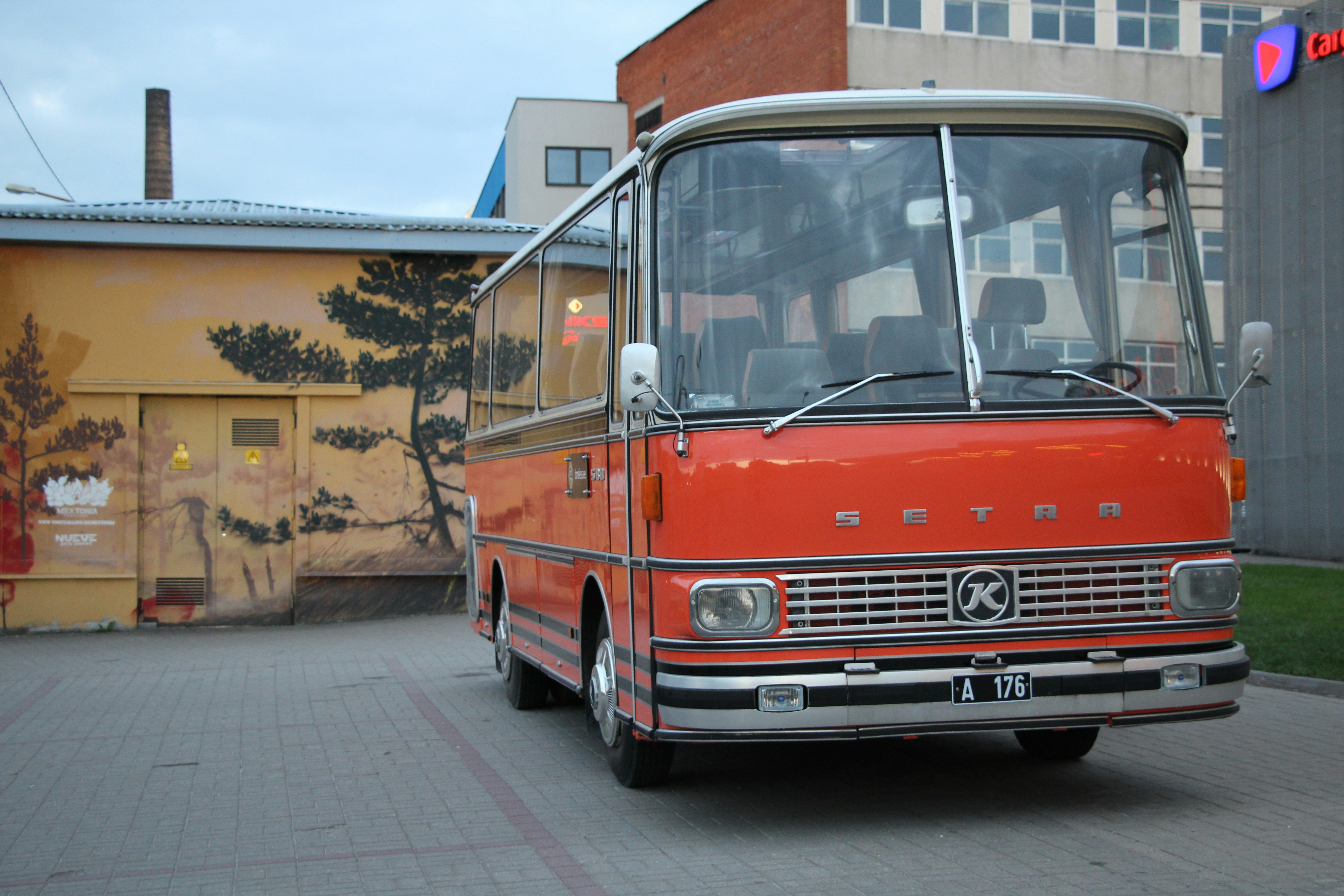 Red Setra Coach Anchored in a Quiet Courtyard