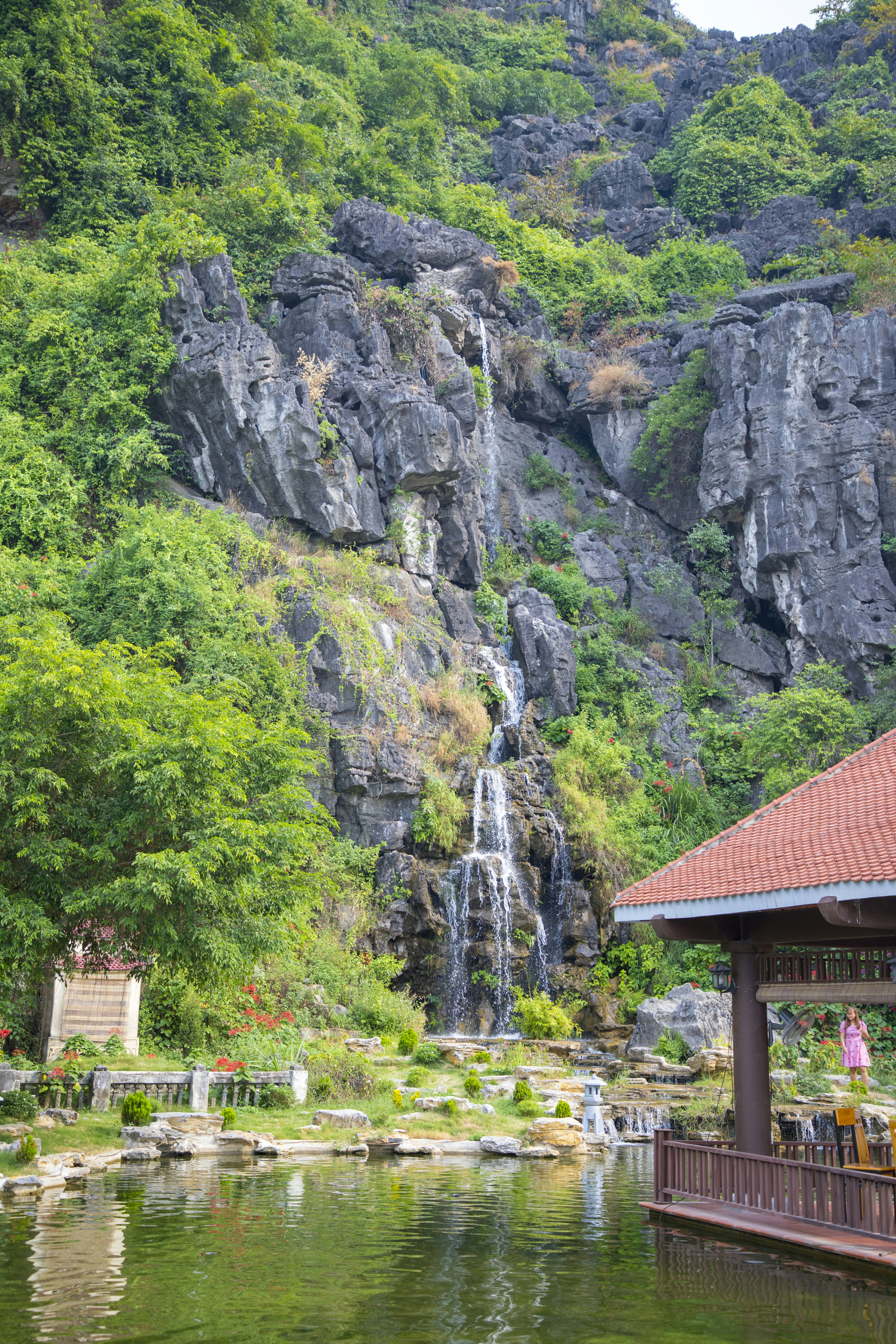 Cascade Between Granite Towers by a Riverside Pavilion