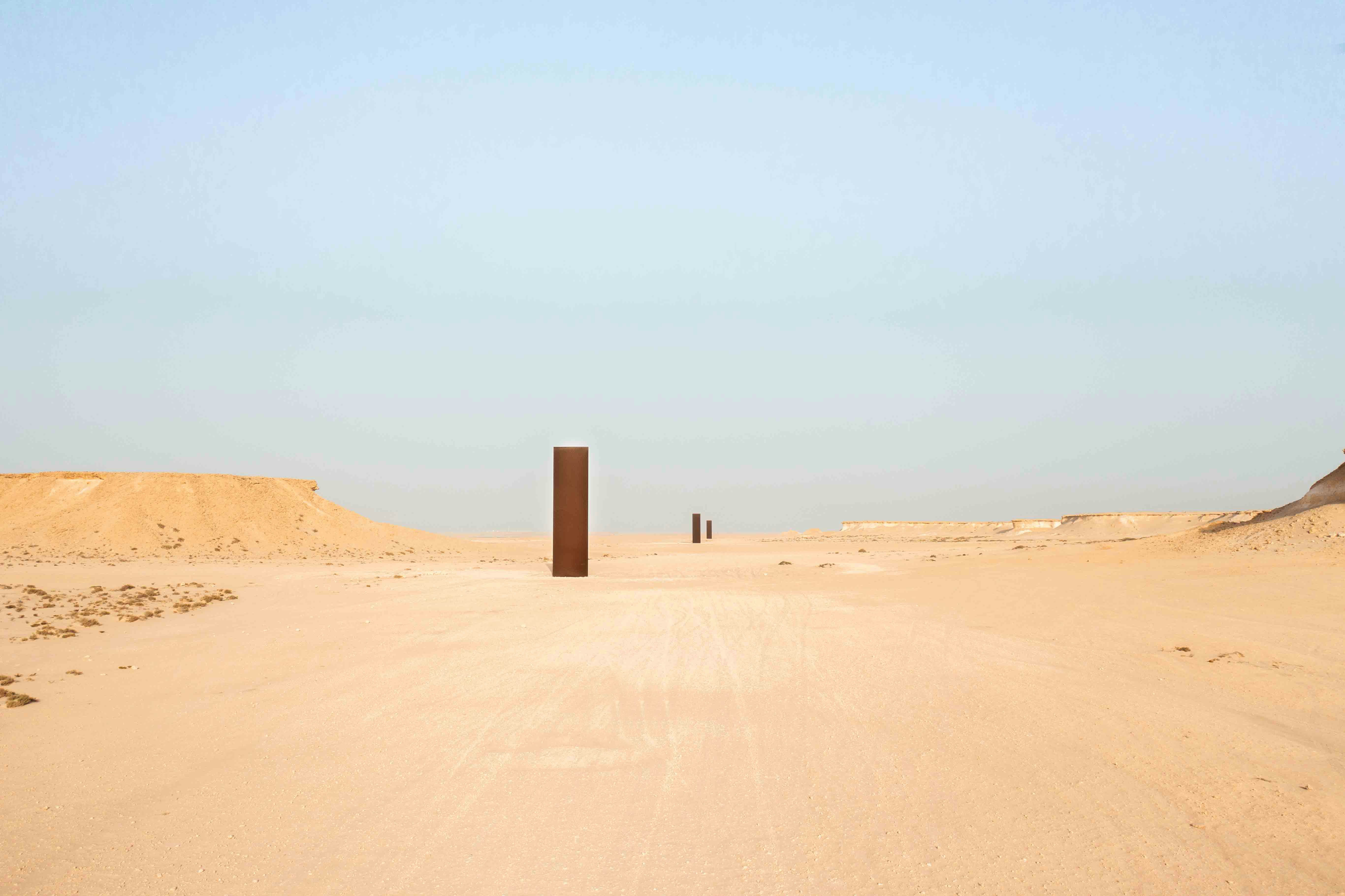 a sandy desert with a tall tower