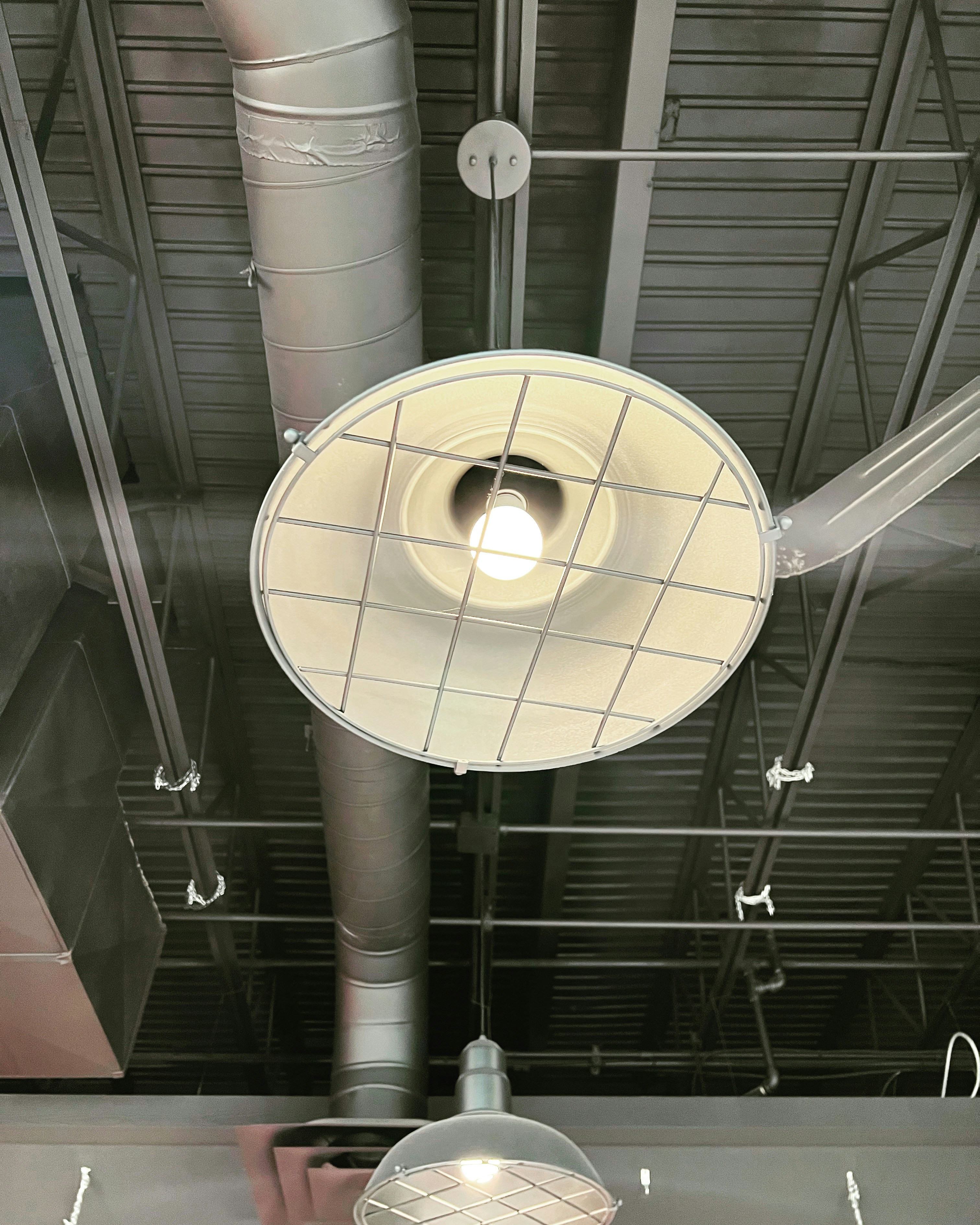 Industrial Halo: A Circle of Light Beneath Exposed Ductwork