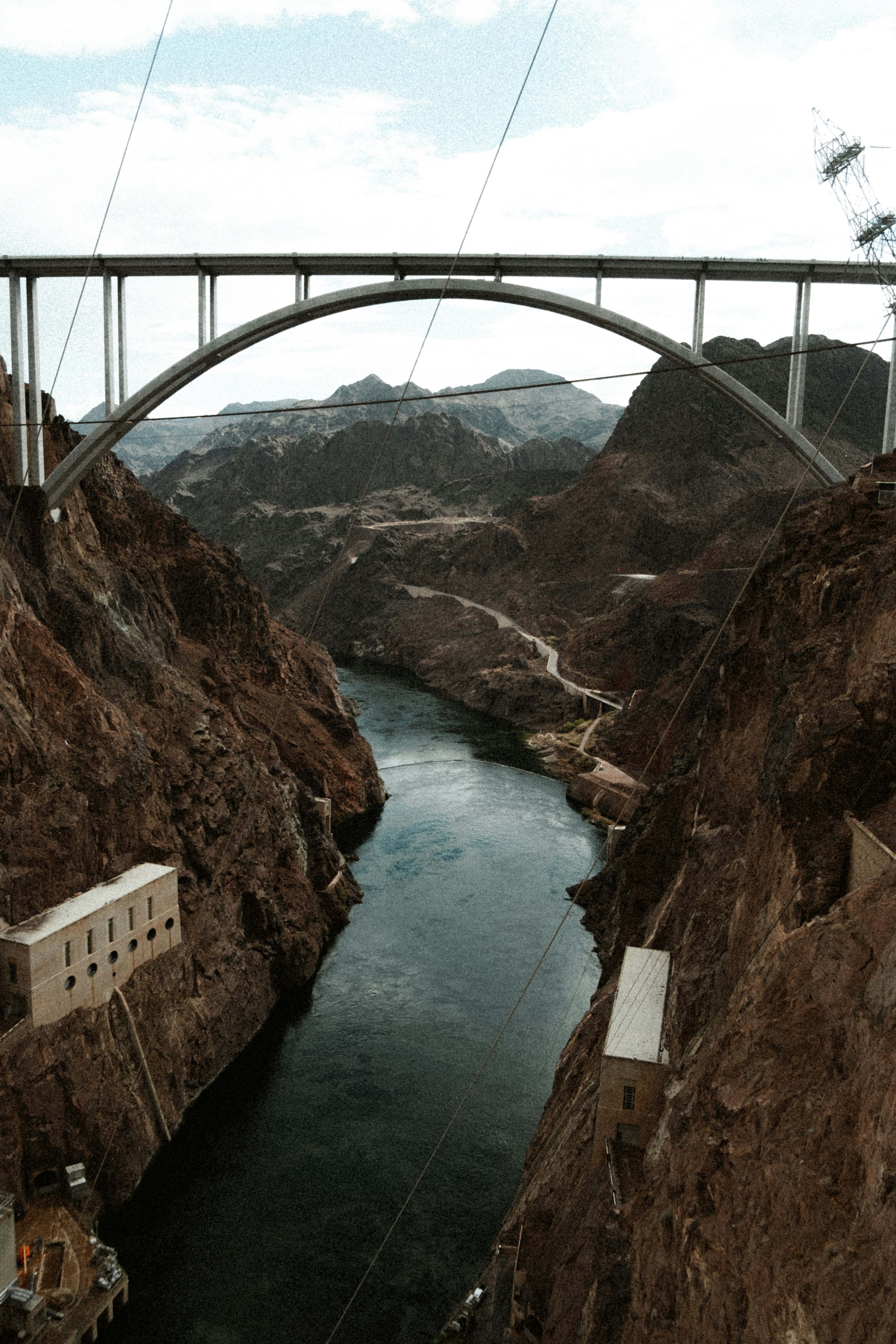 Arch Over the Gorge: A Curved Bridge Framing a Winding River Between Rugged Cliffs