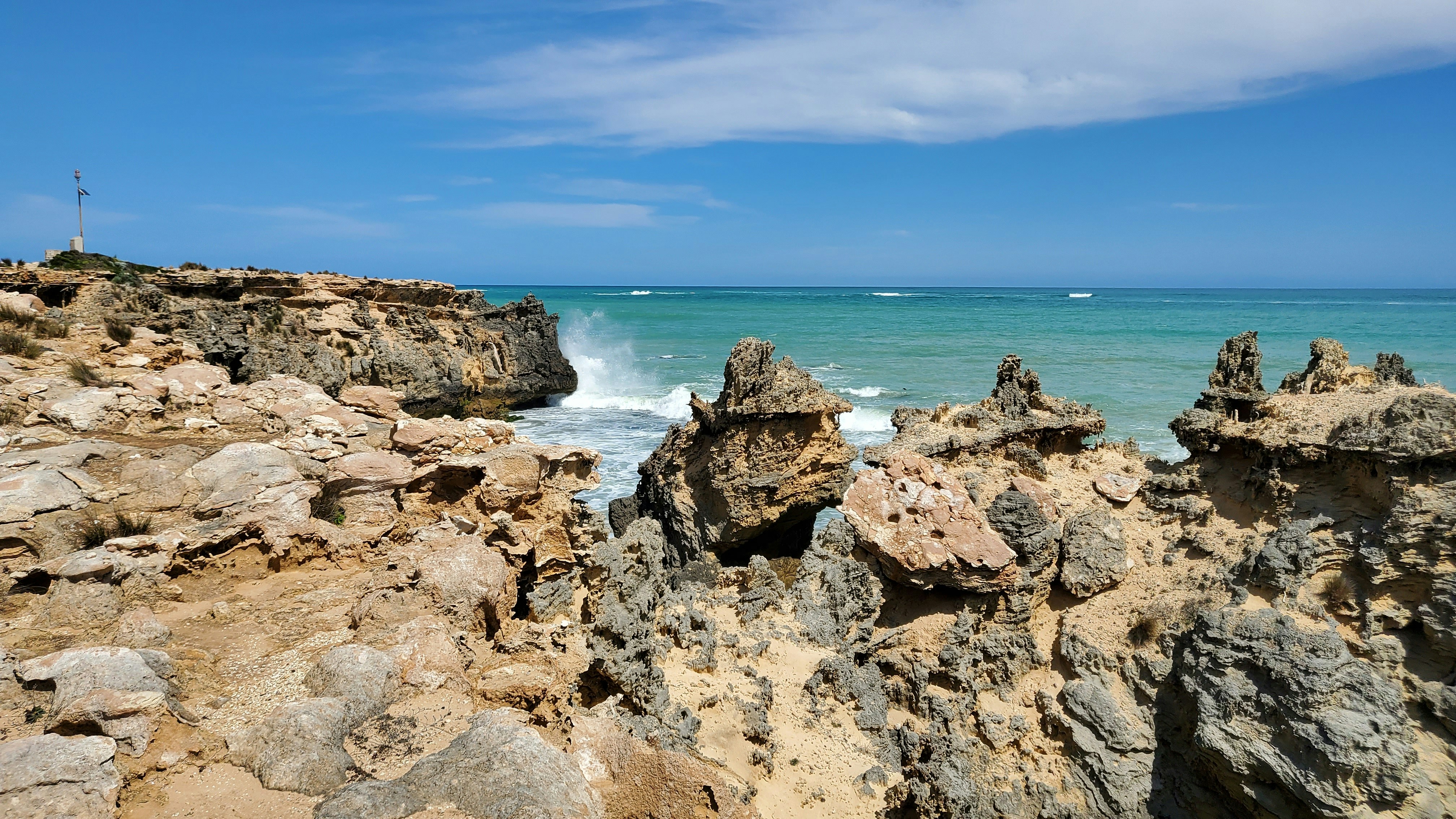 a rocky beach with a tower in the distance