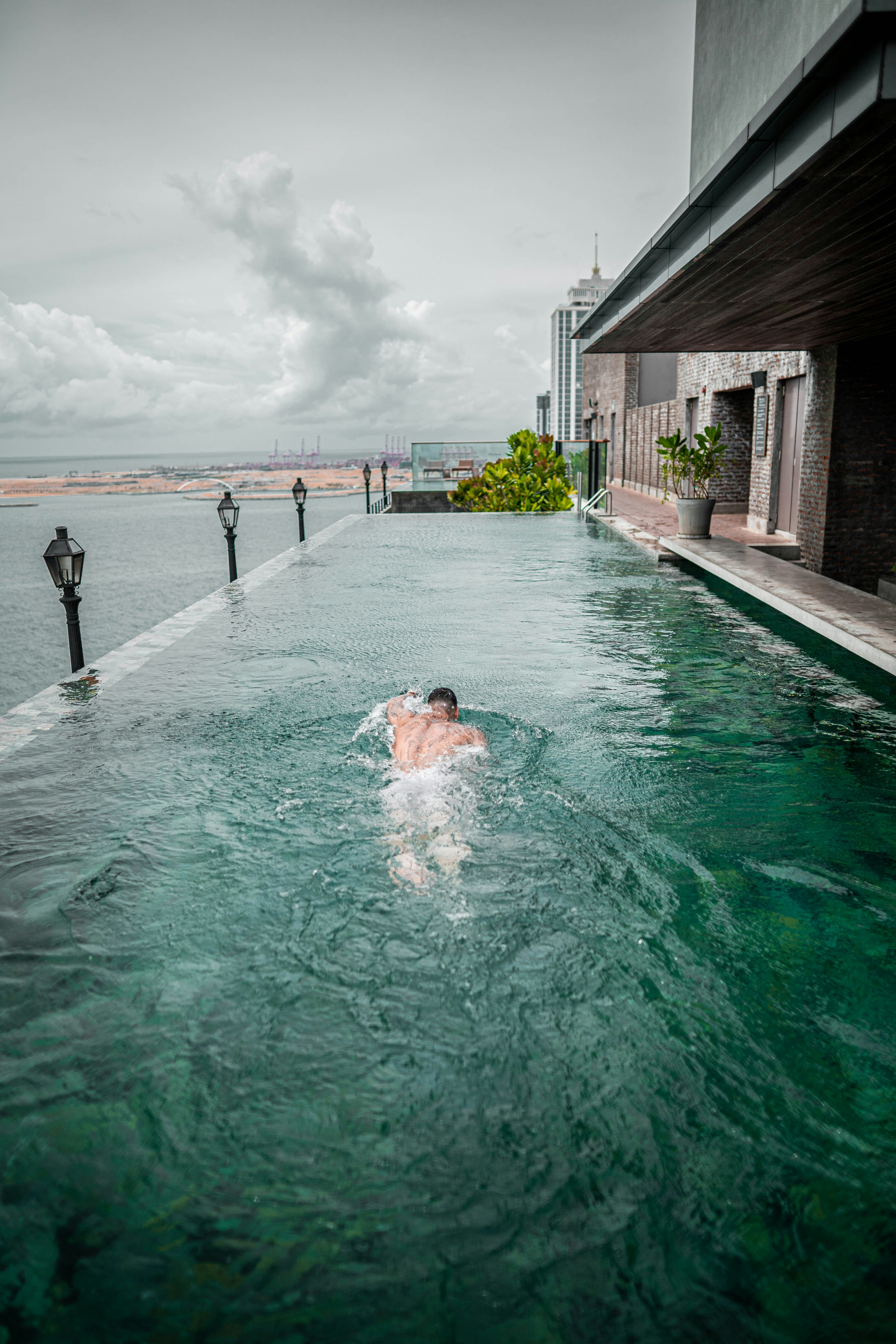 Rooftop Infinity: A swimmer gliding along a city-enabled pool