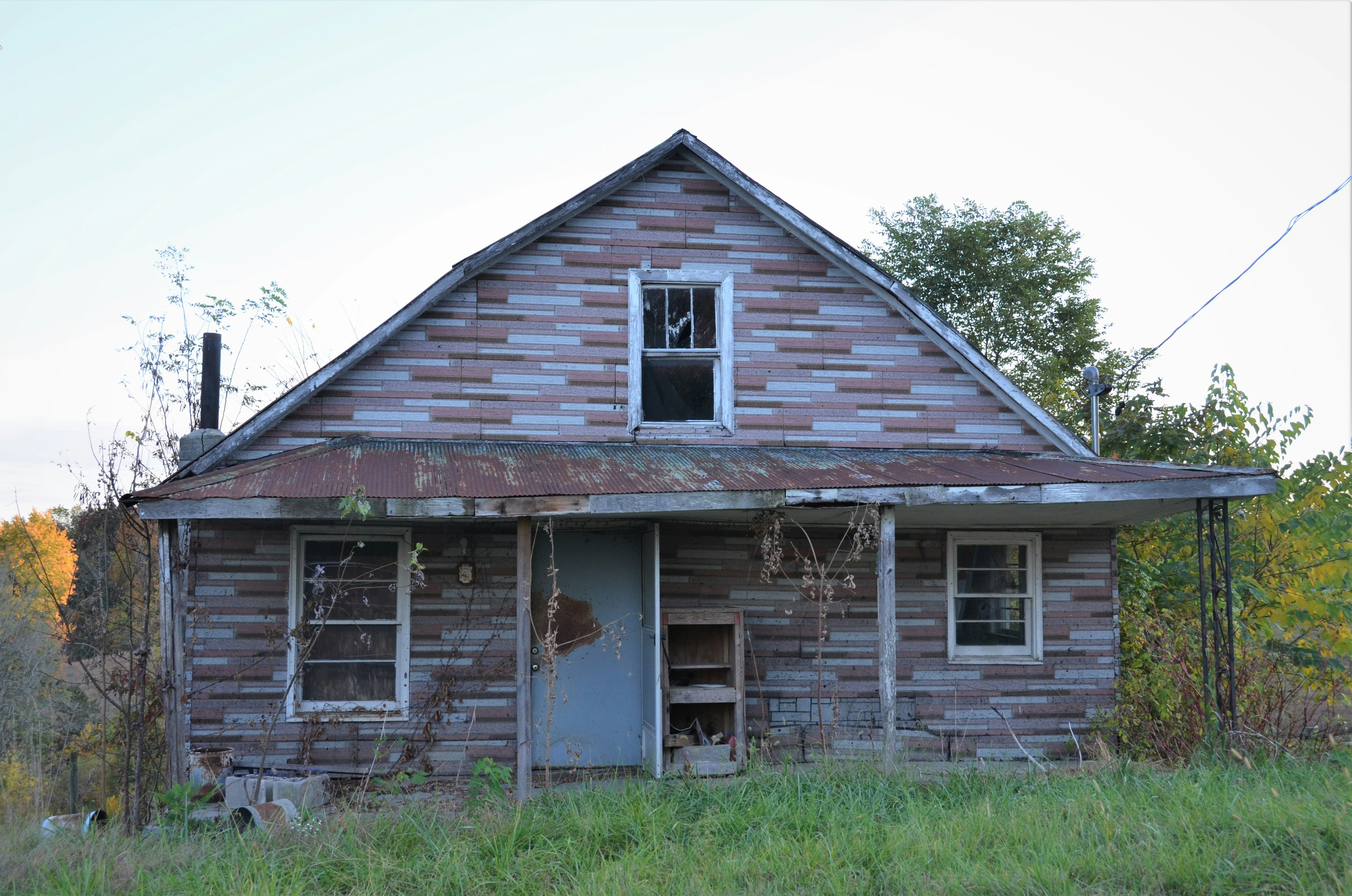 A run down house with a broken window photo – Free Building Image on ...
