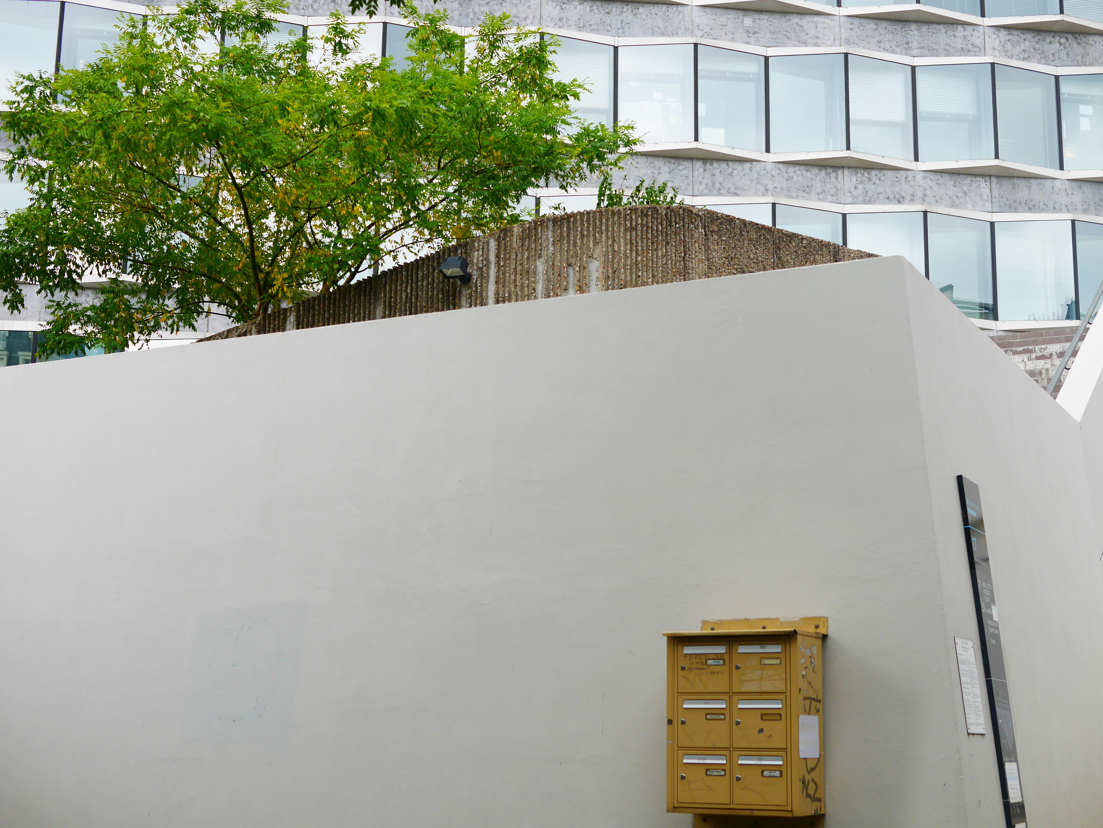 Urban Minimalism: Mailboxes Anchored to a Quiet Concrete Facade