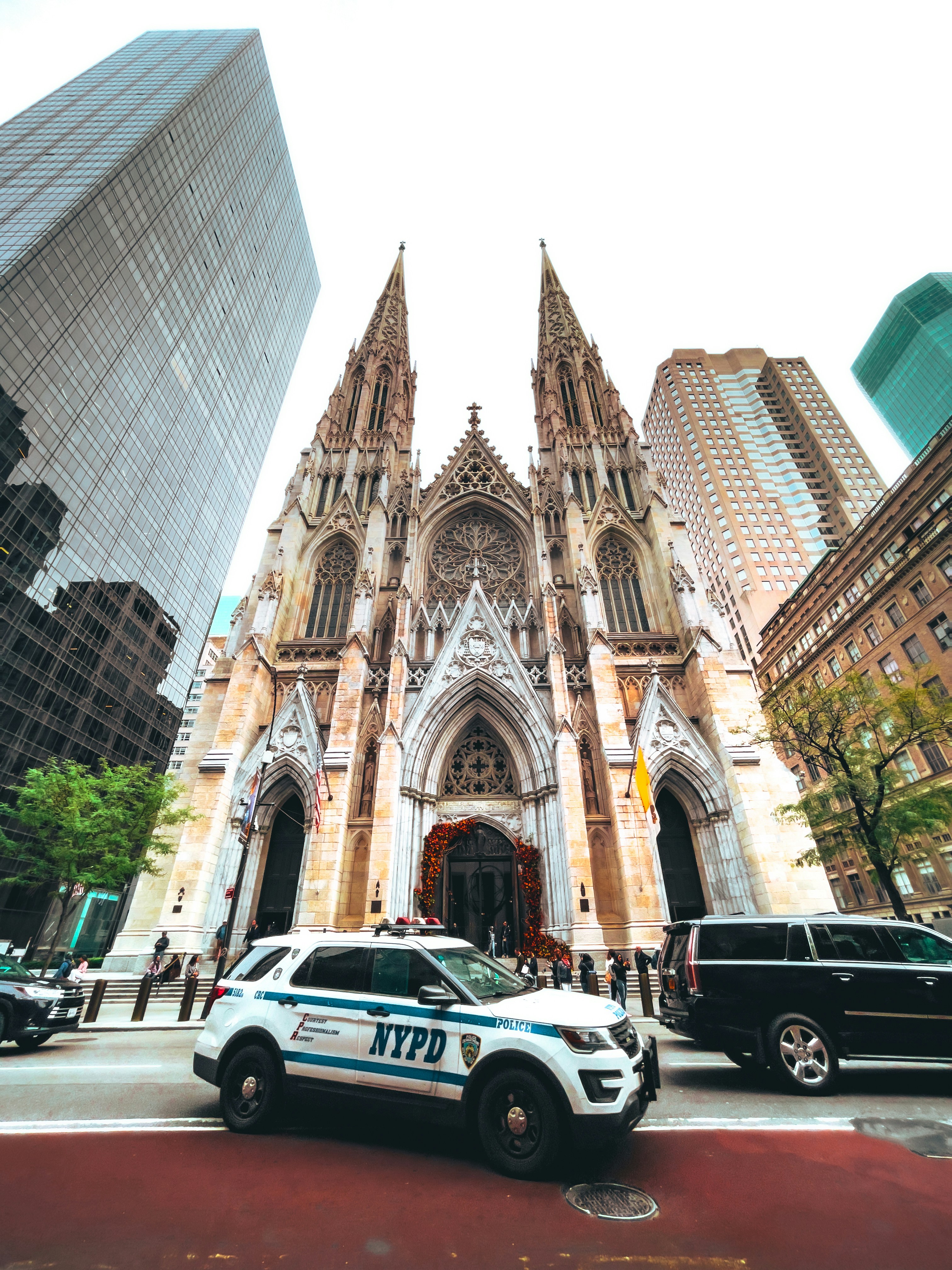 a police car parked in front of a cathedral