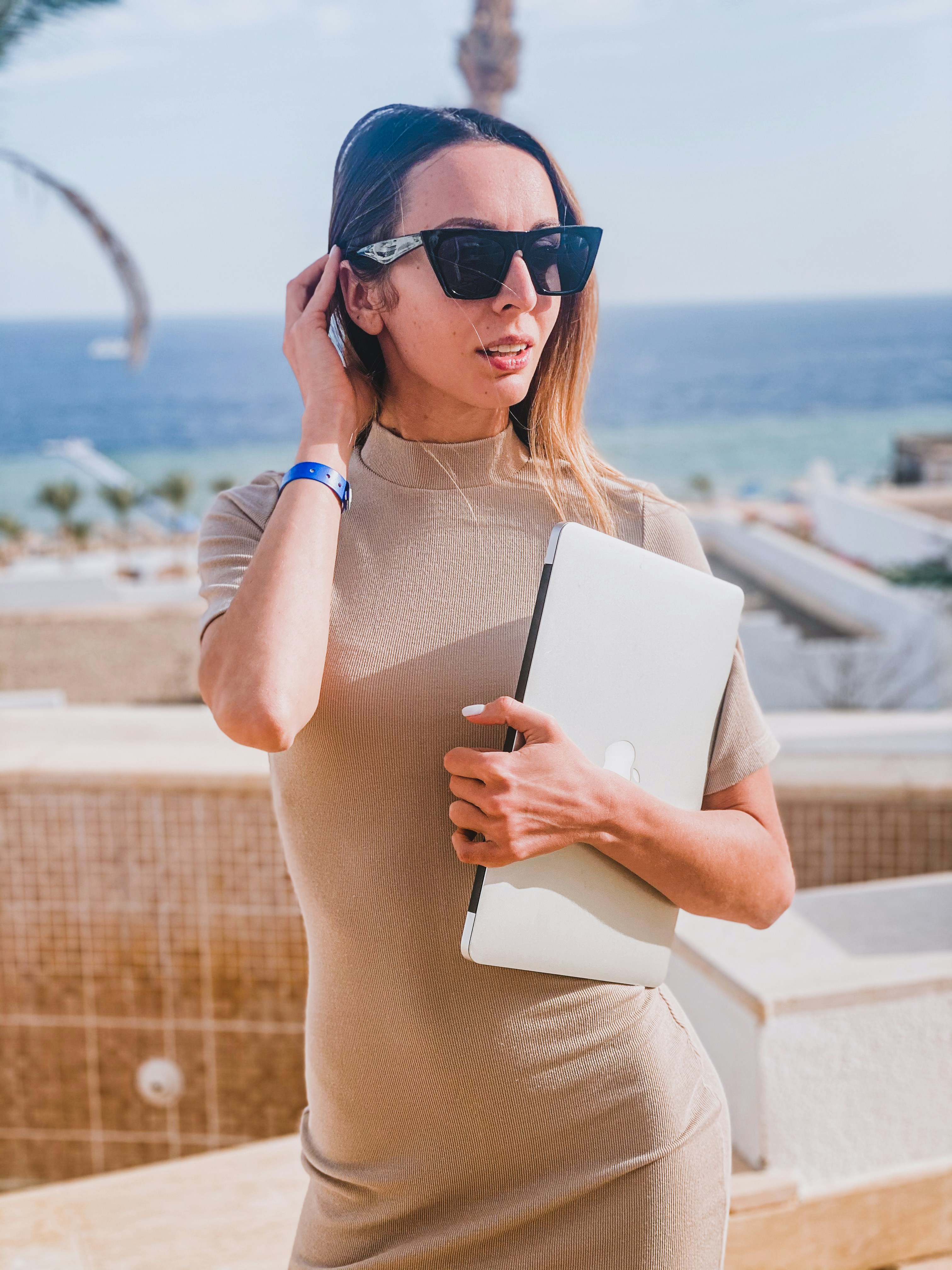 Laptop in Hand, Ocean in View: A Beachside Portrait of Focused Poise