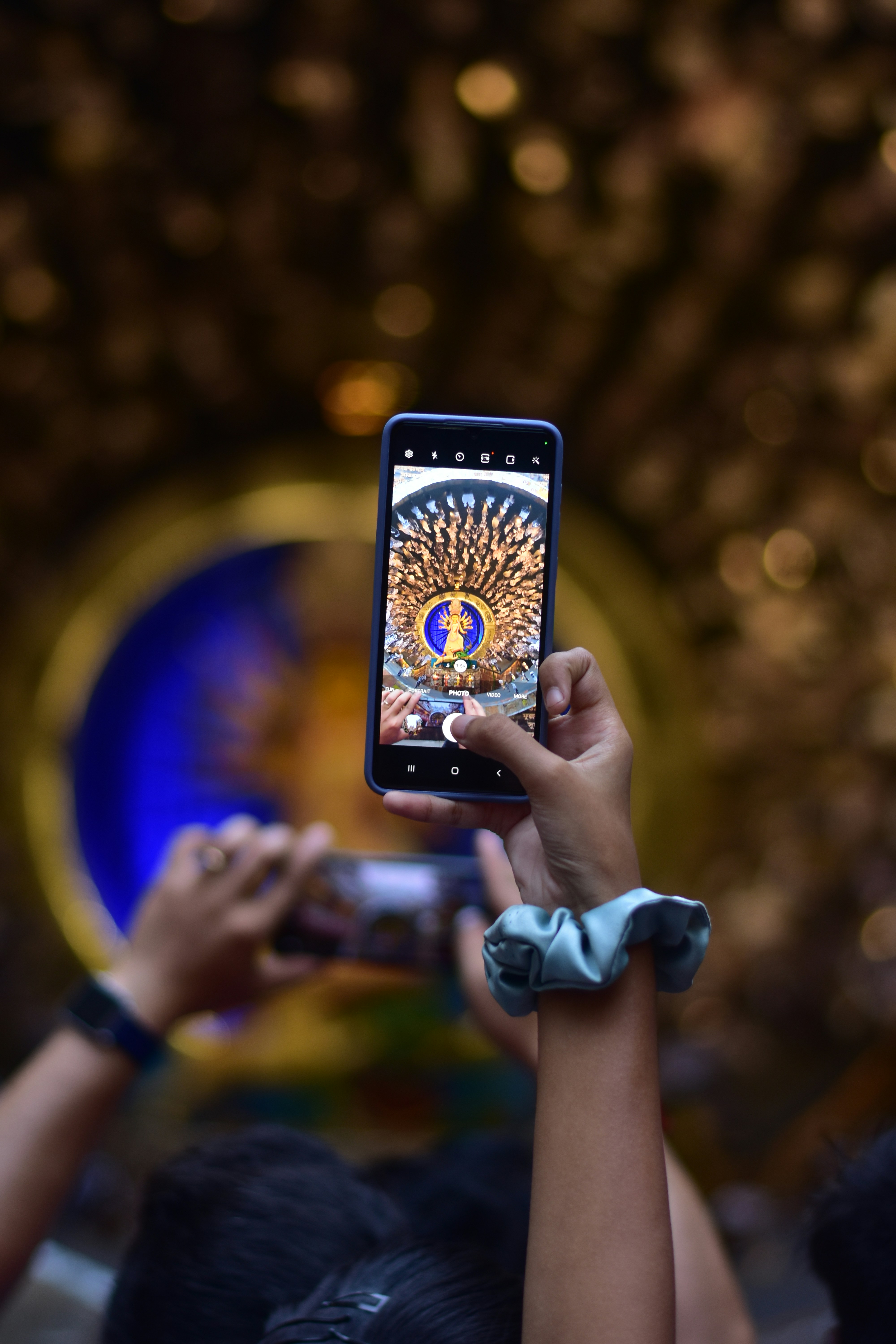 Pocket Shrine Reflection: Golden Halo Framed by a Phone