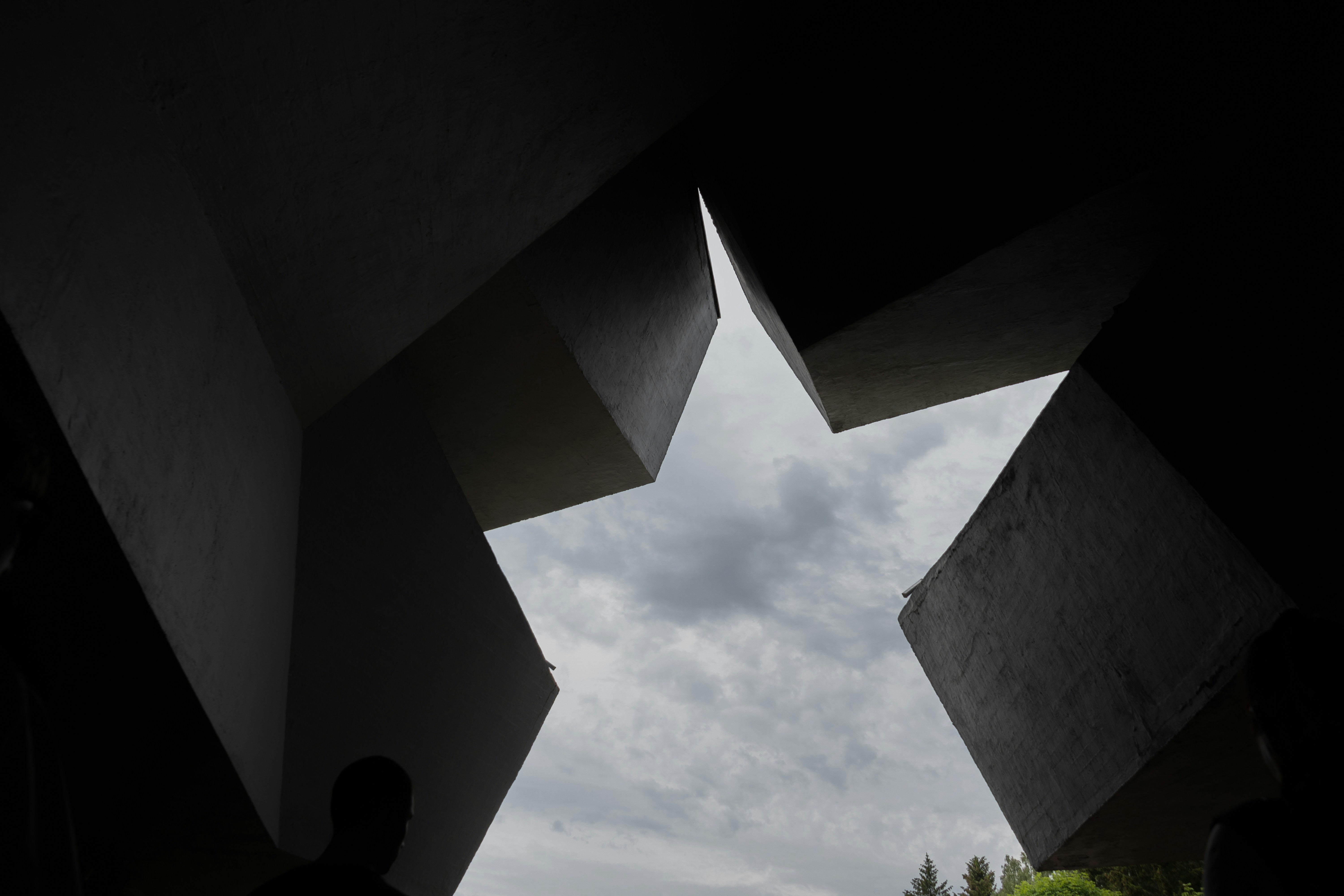 Concrete structure with a star-shaped opening revealing a cloudy sky.