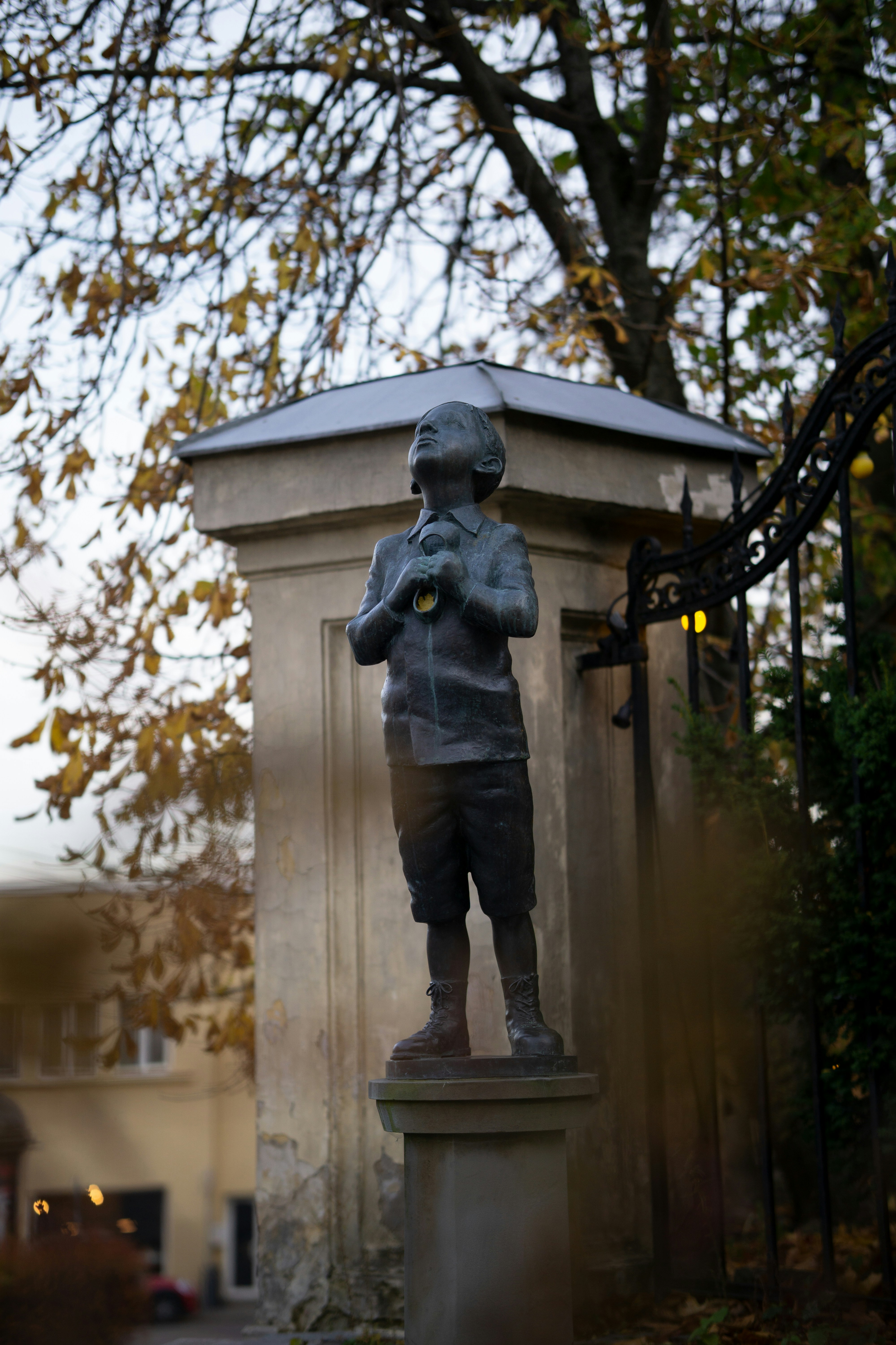 Bronze Boy at the Gate: Quiet Reverie in Autumn Light