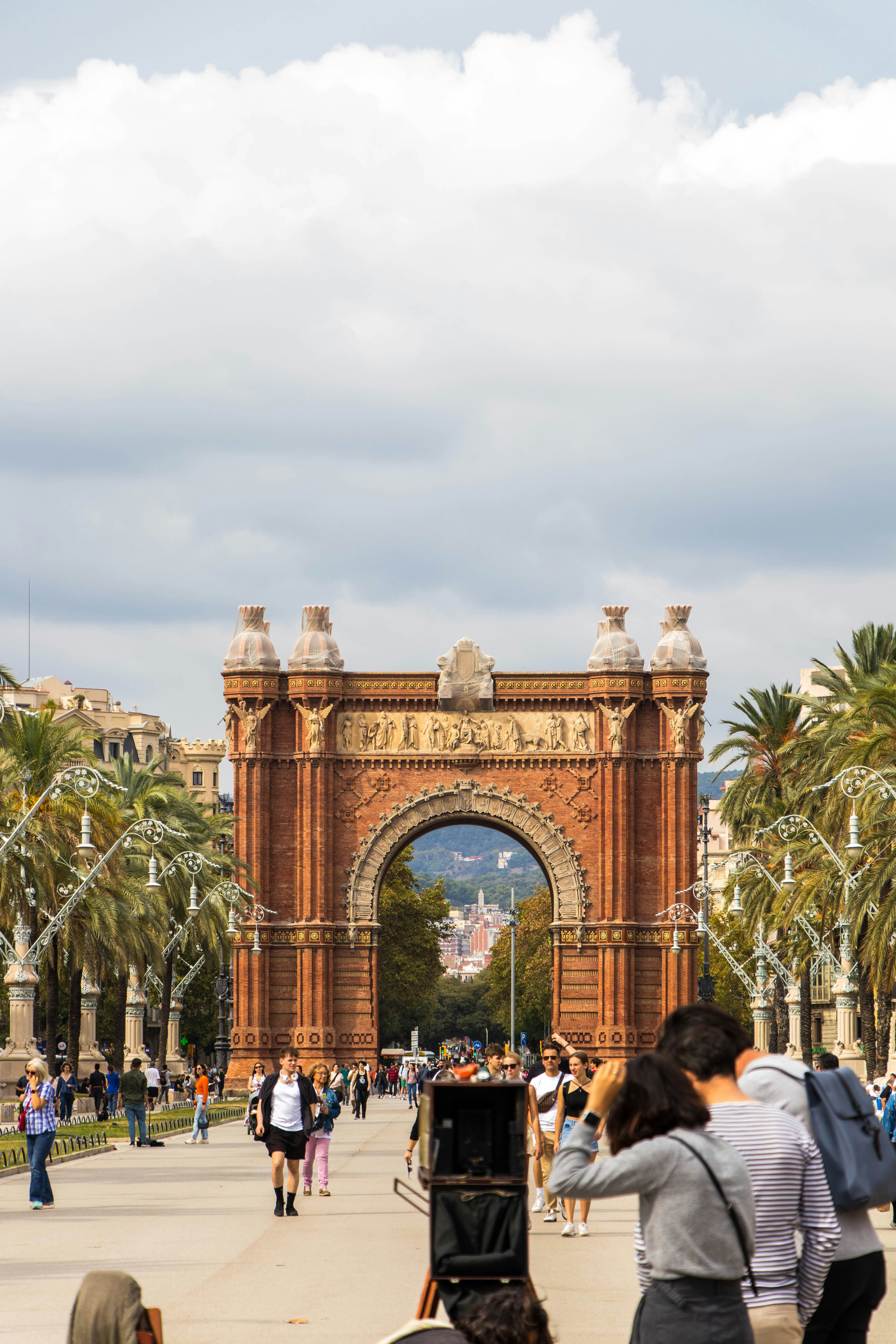 a large stone archway with people walking around