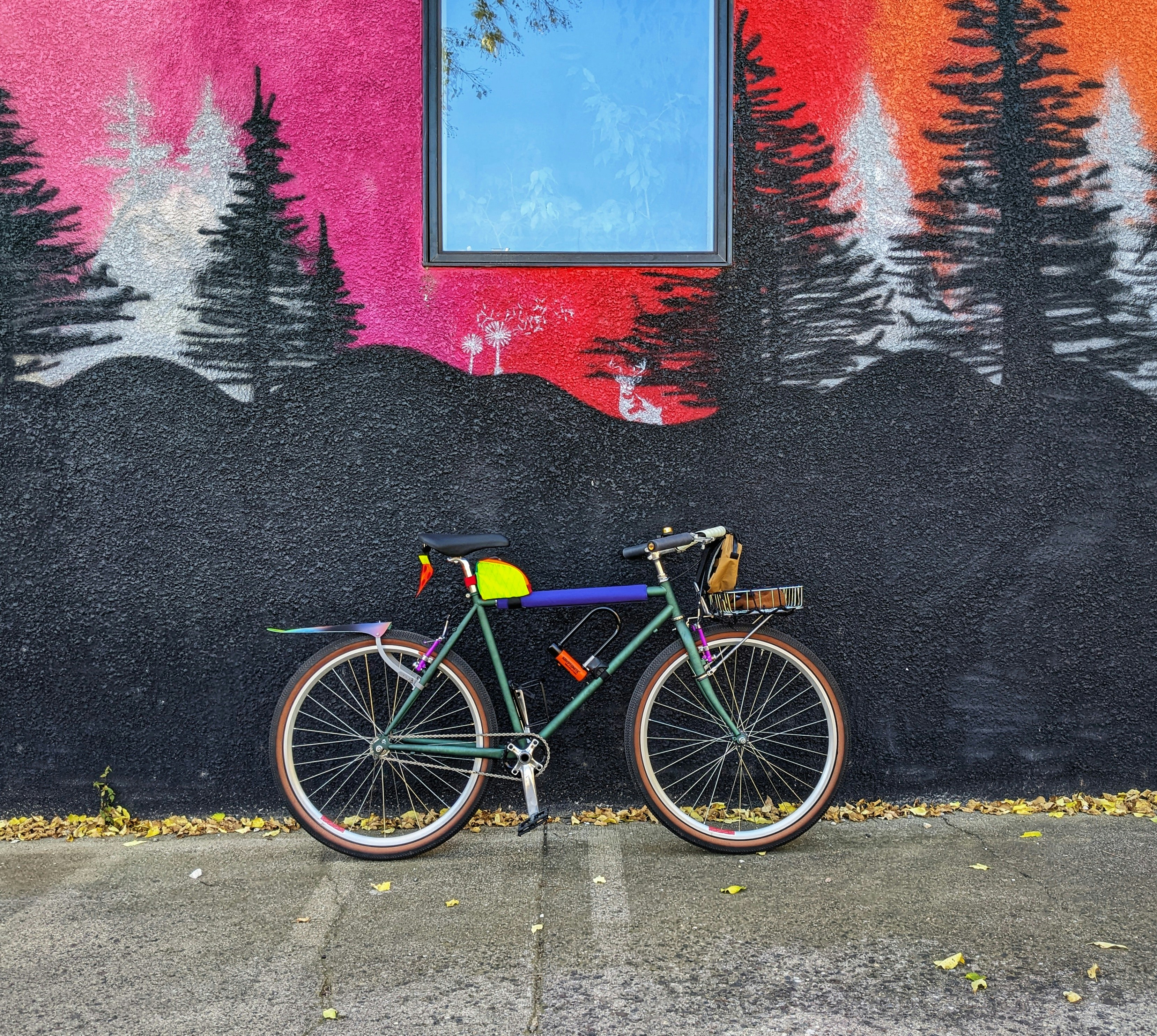 Colorful bicycle against mural: a quiet street scene with a vibrant frame